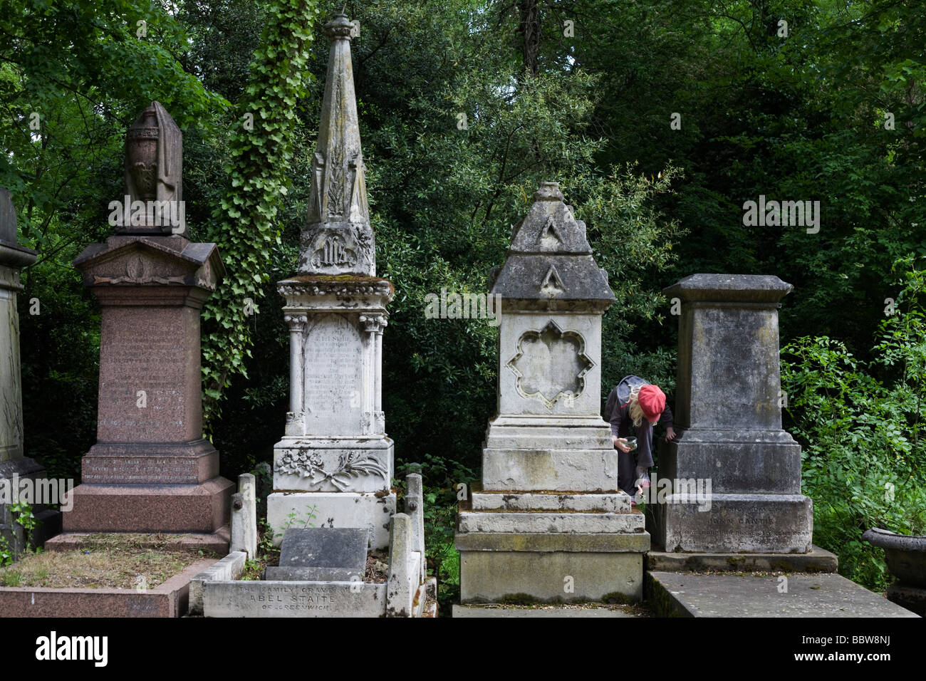 Young girls play around grand Victorian memorial grave stones in ...