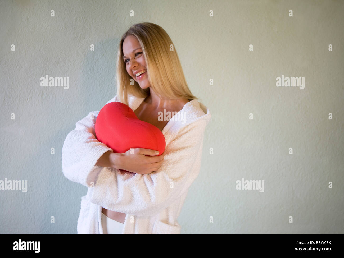 young woman hugging heart shaped pillow Stock Photo - Alamy
