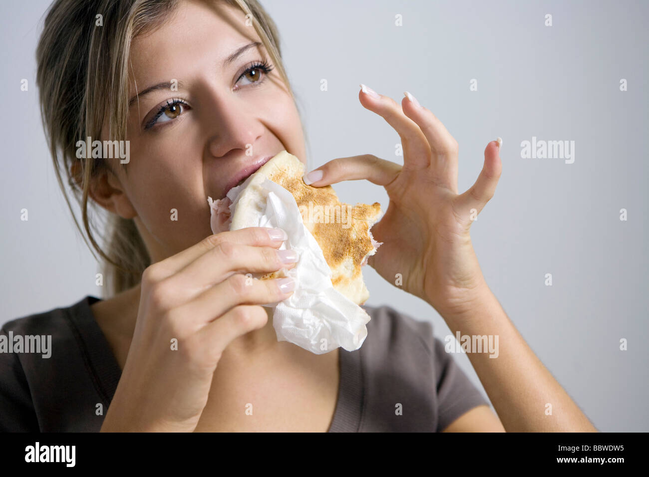 young woman eating a sandwich Stock Photo - Alamy