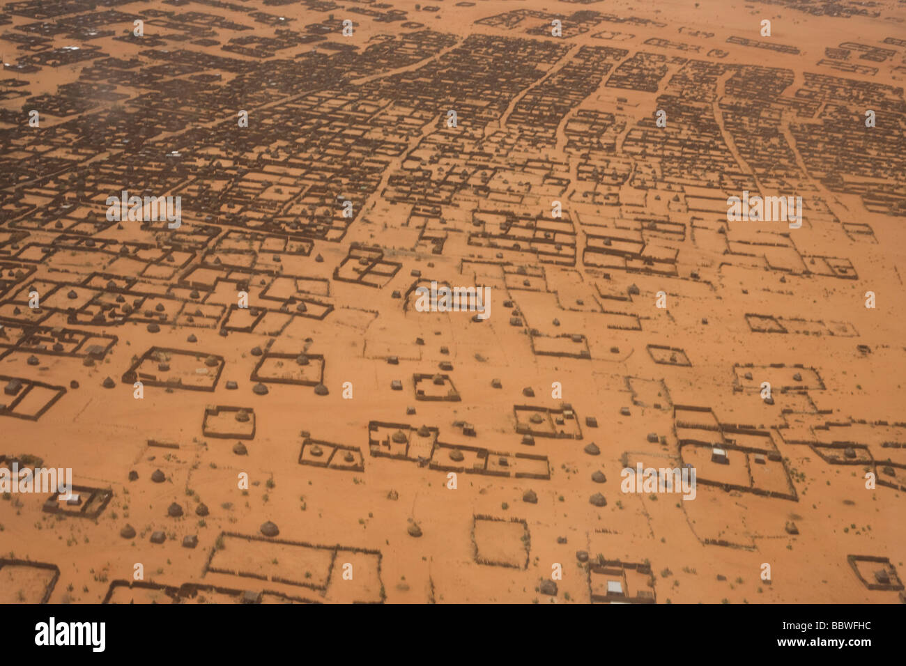 Aerial view of scorched red Saharan earth and basic housing in Al ...