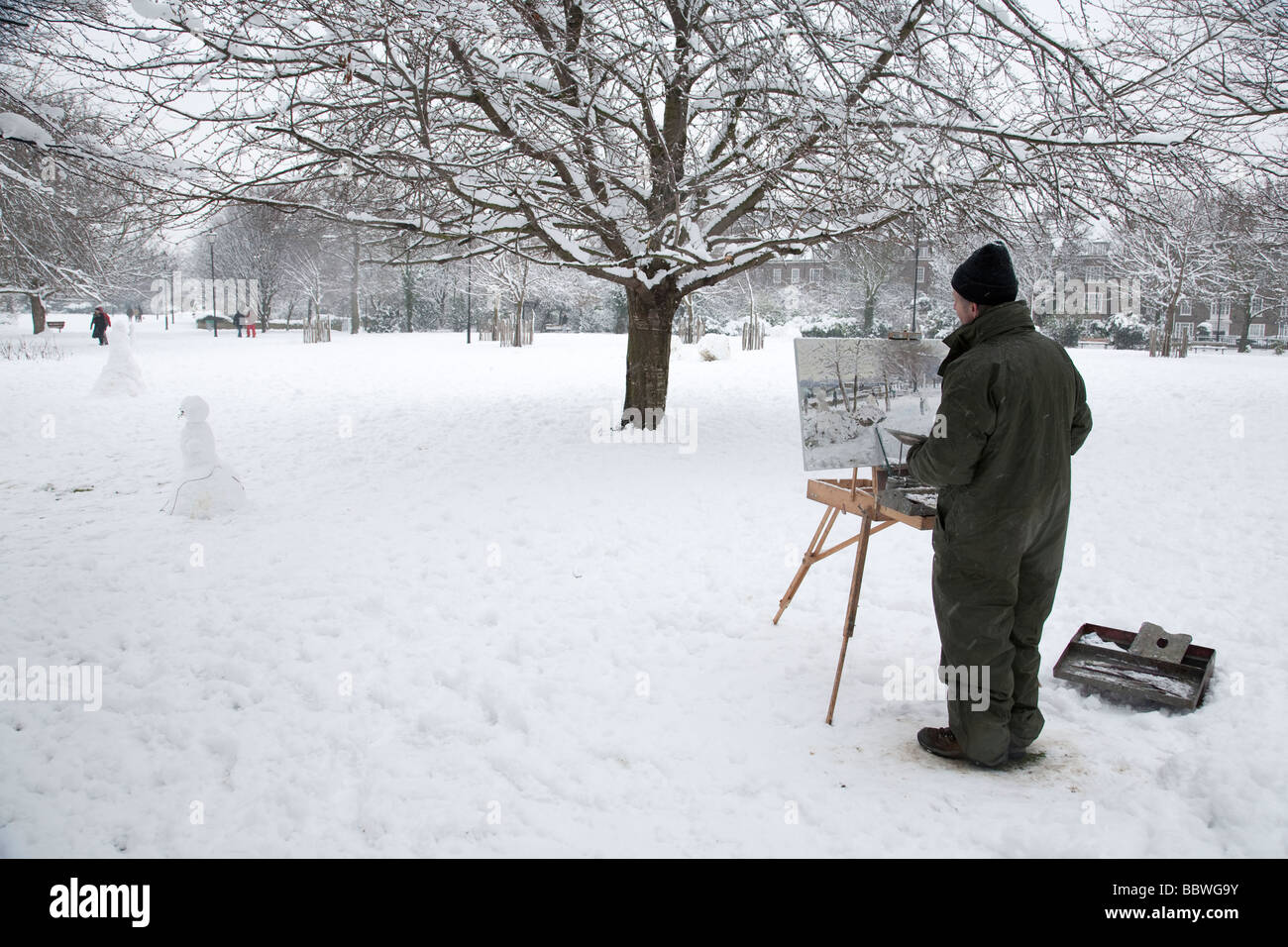 A male artist painting a winter snow scene in Furnival Gardens ...