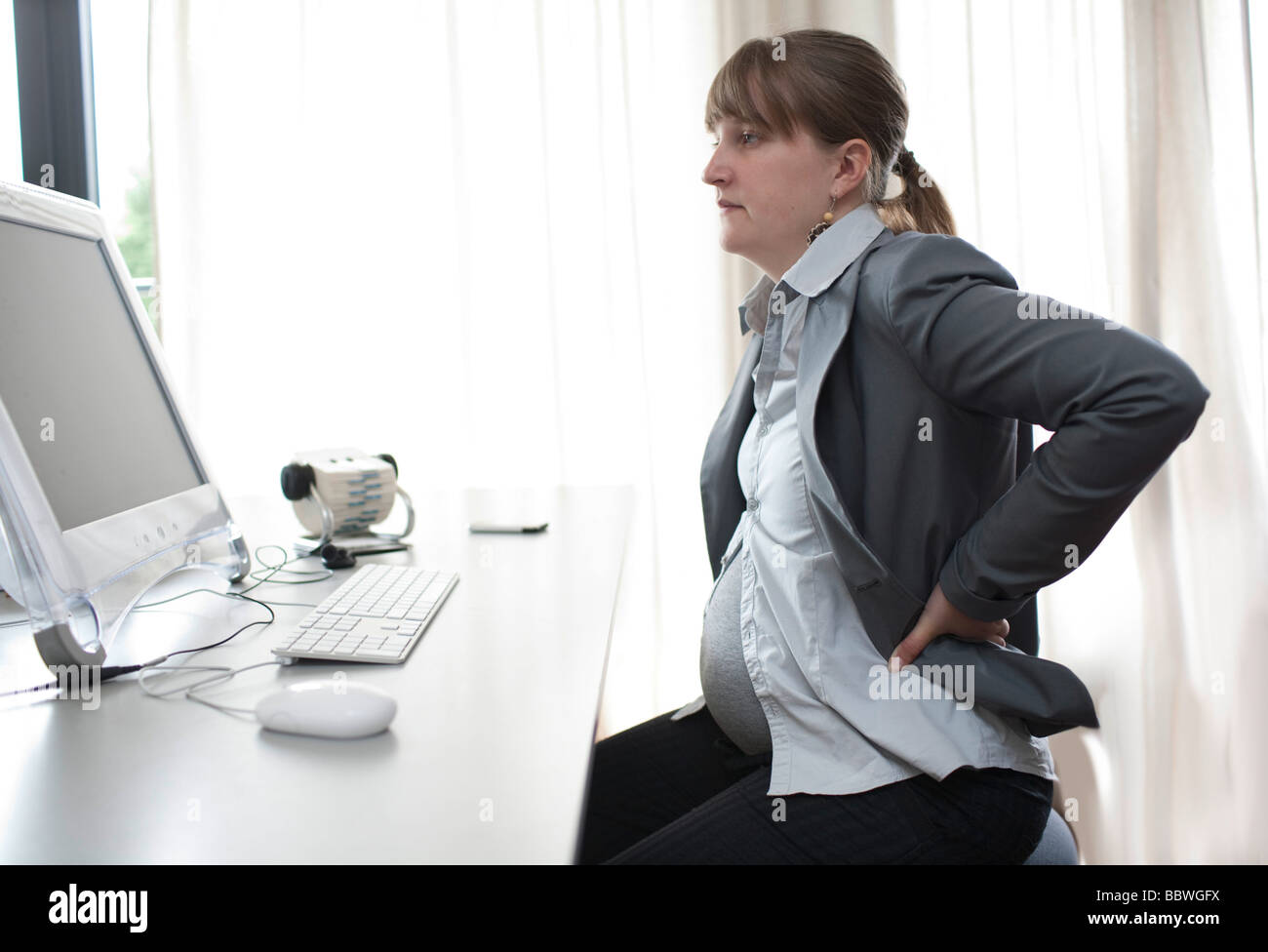 Pregnant woman working at a computer Stock Photo - Alamy