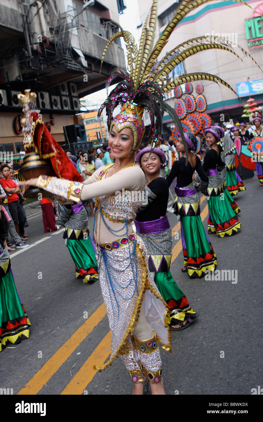 woman with sinulog costume and a Santo Niño doll in the sinulog parade ...
