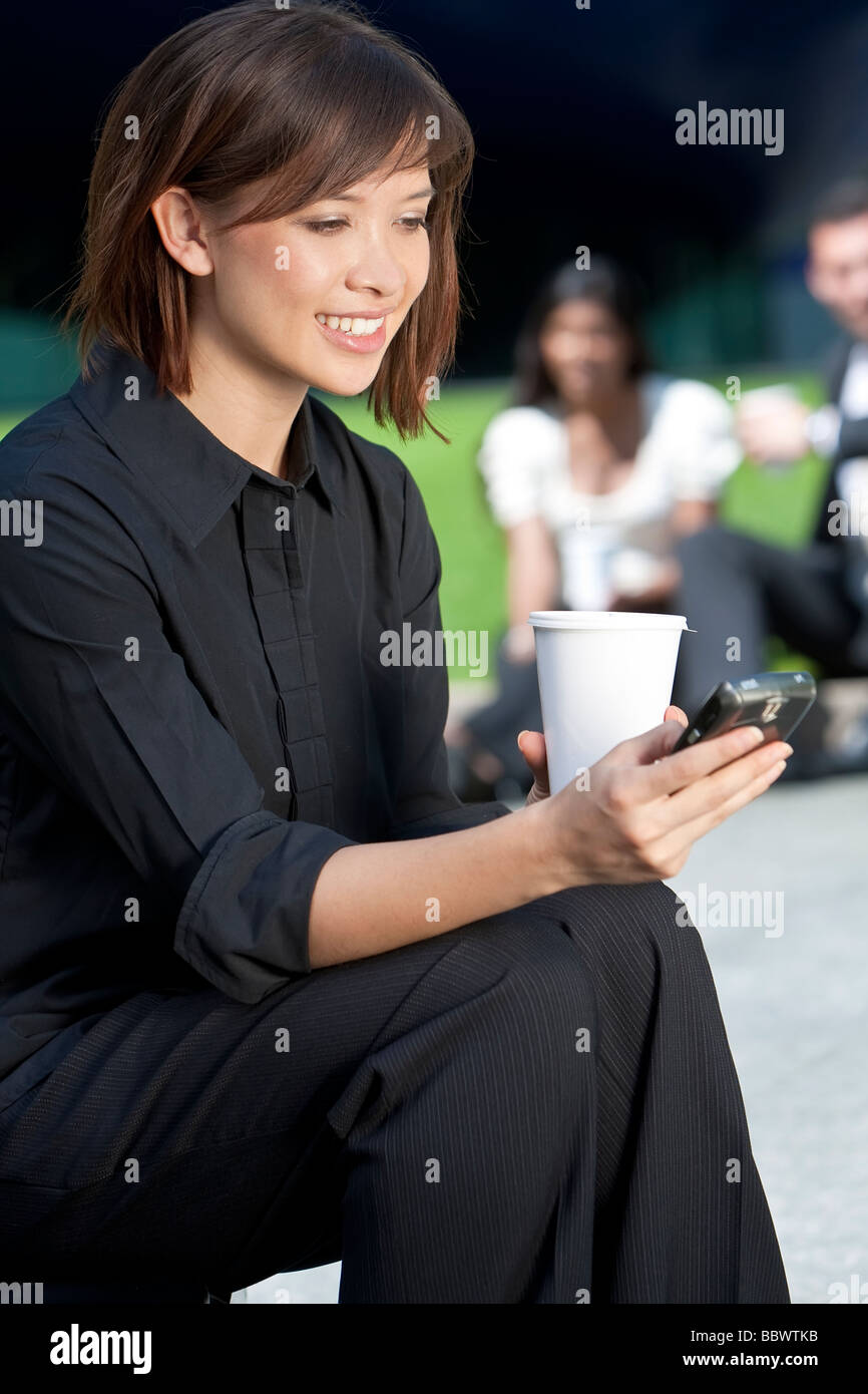 A beautiful young Eurasian woman with a wonderful smile texting on her ...