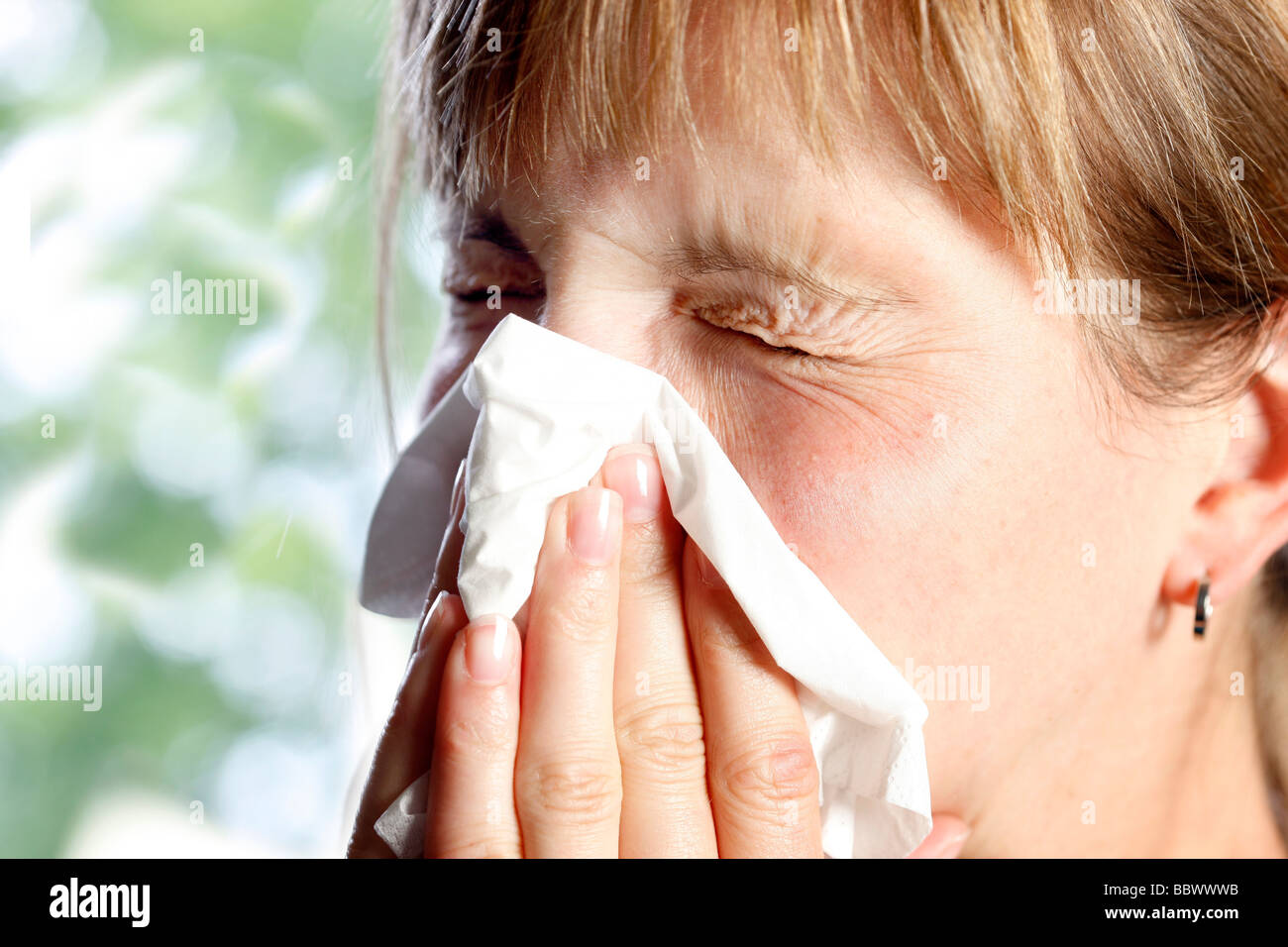 Woman is sneezing, has a cold or an allergy, uses a soft tissue Stock ...
