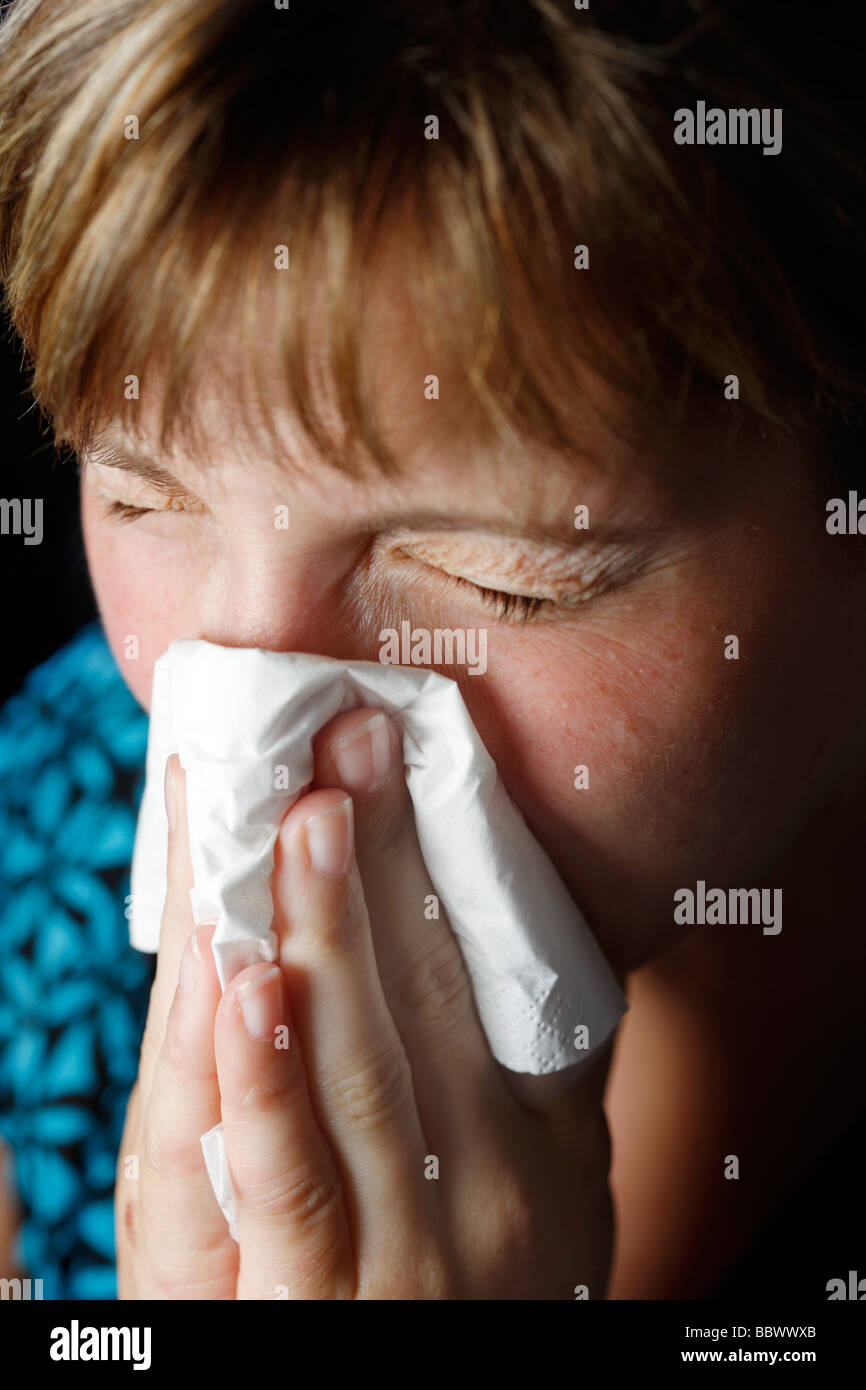 Woman is sneezing, has a cold or an allergy, uses a soft tissue Stock ...