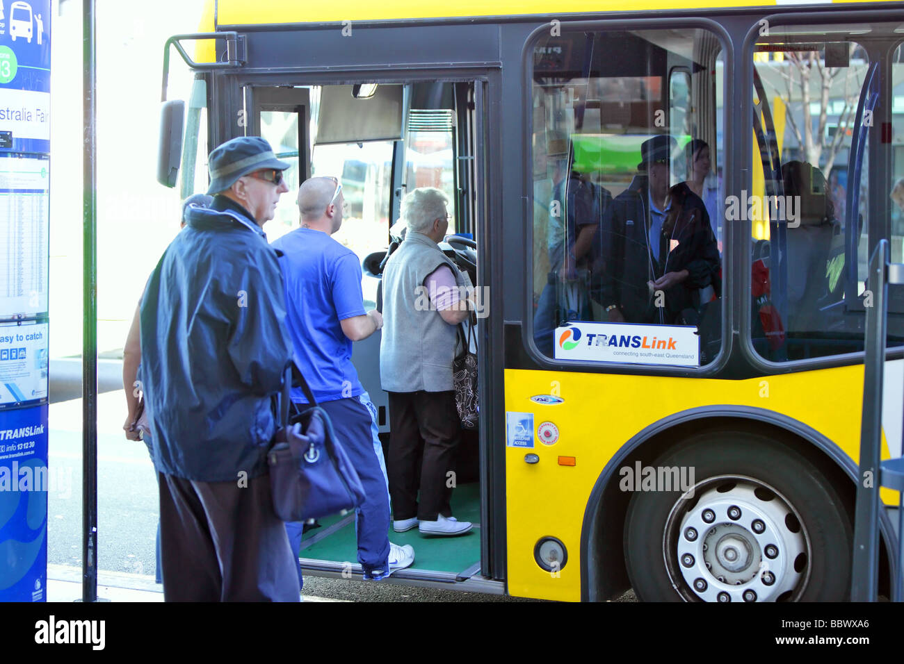 People getting on and off a public transport bus at a stop in the city ...