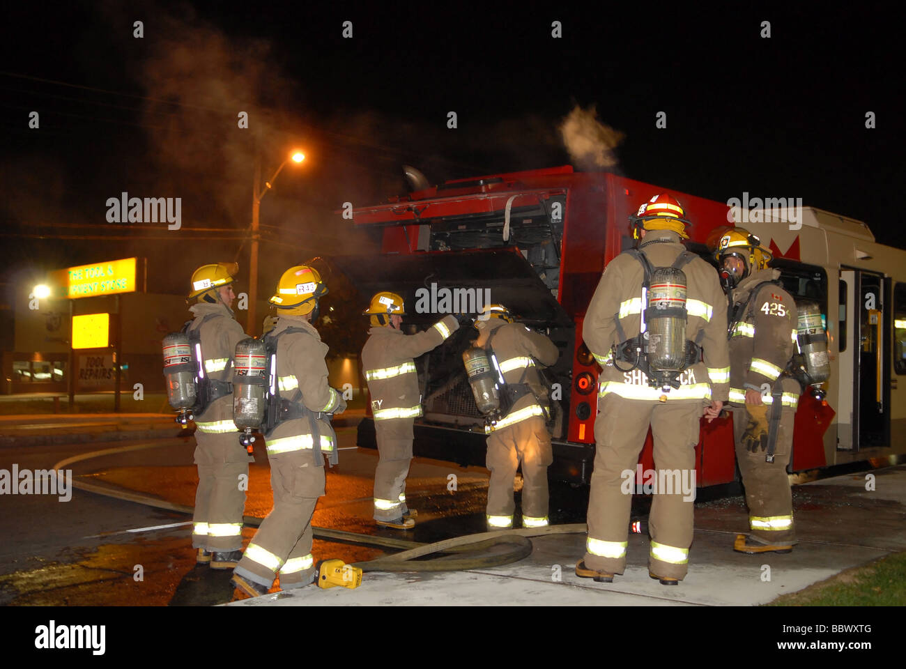 Fire crews inspect the engine compartment to determine the cause of a ...