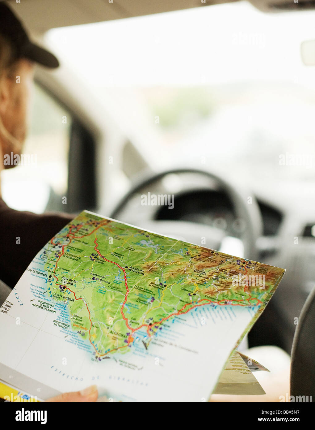Man in a car watching a map Spain Stock Photo - Alamy