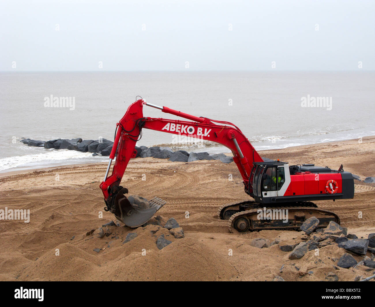 digger repairing norfolk sea defences Stock Photo - Alamy