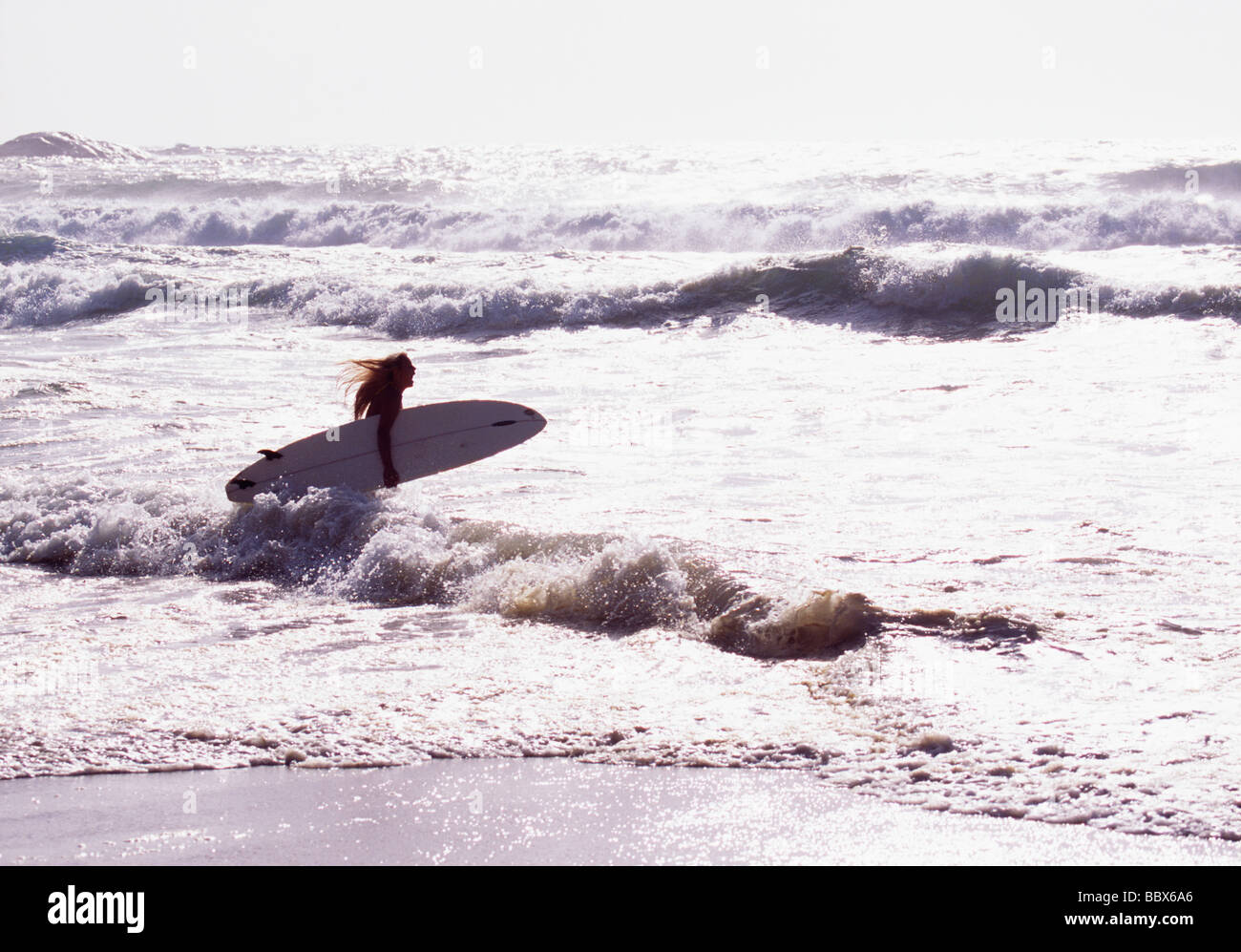 Woman with surfboard in sea Stock Photo - Alamy