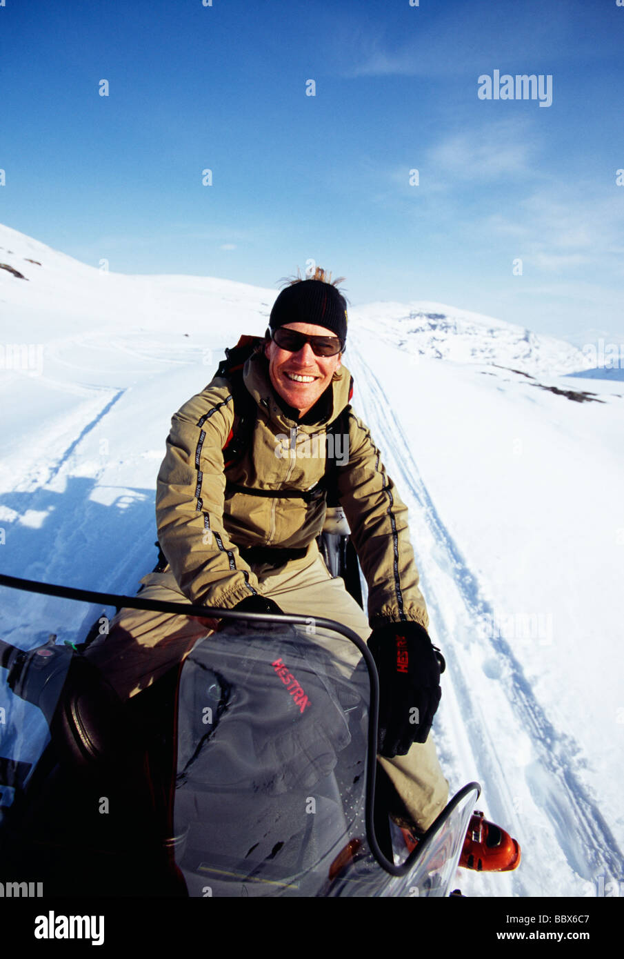 Young man riding snowmobile Stock Photo - Alamy