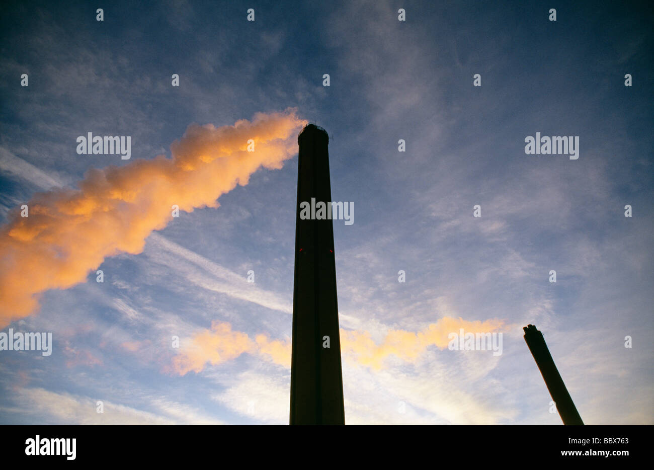 Silhouette of chimneys emitting fumes low angle view Stock Photo - Alamy