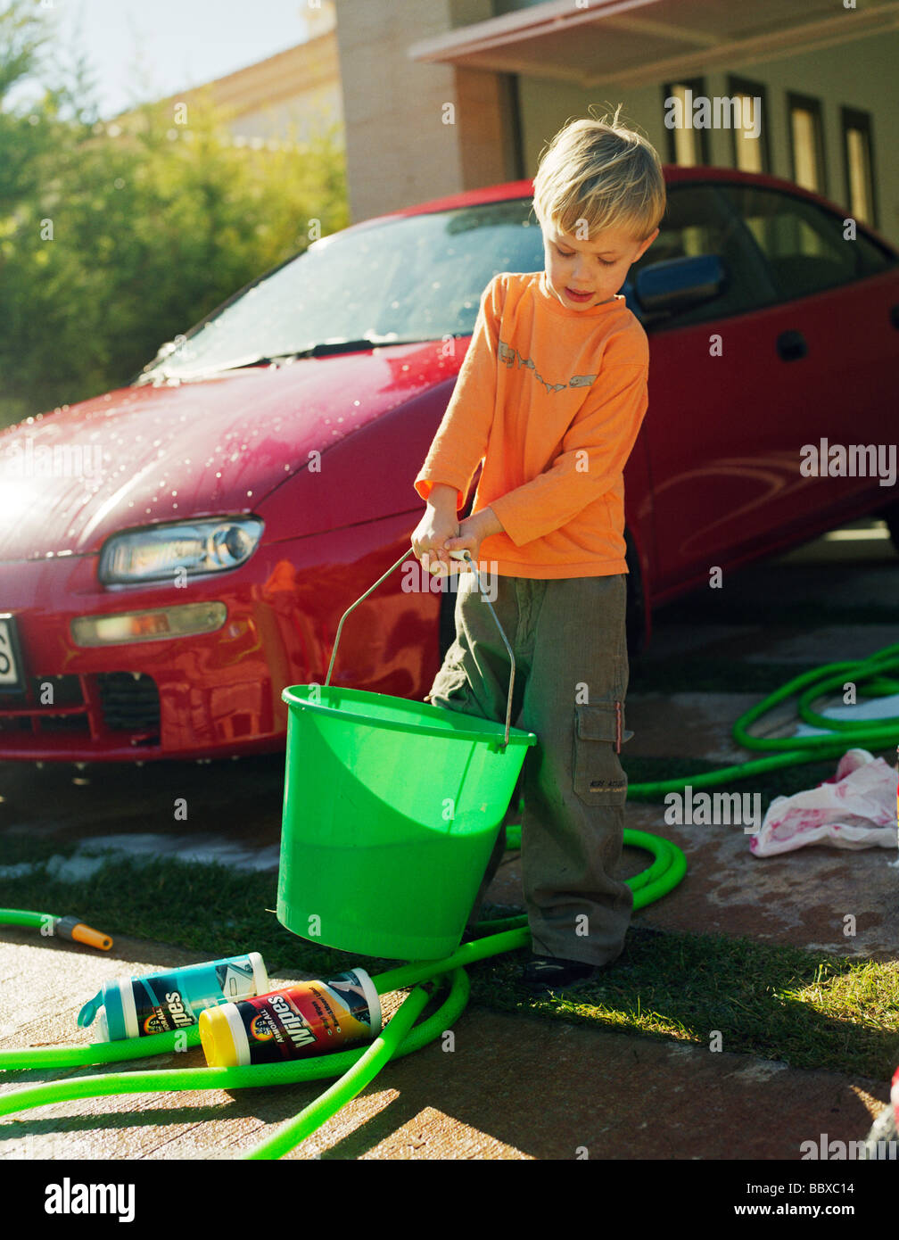 A boy washing a red car Stock Photo - Alamy