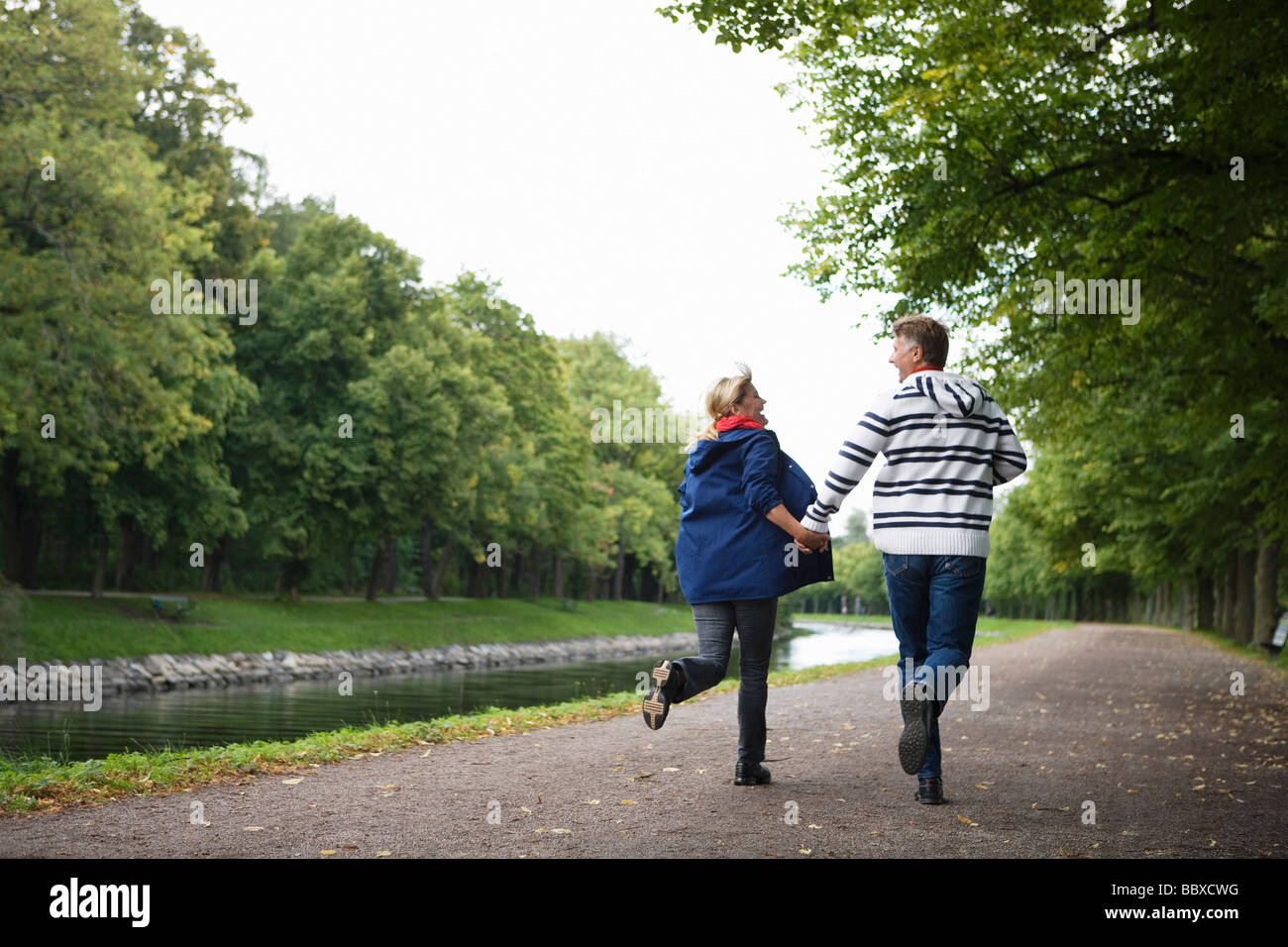 A couple running hand in hand in the park Sweden Stock Photo - Alamy