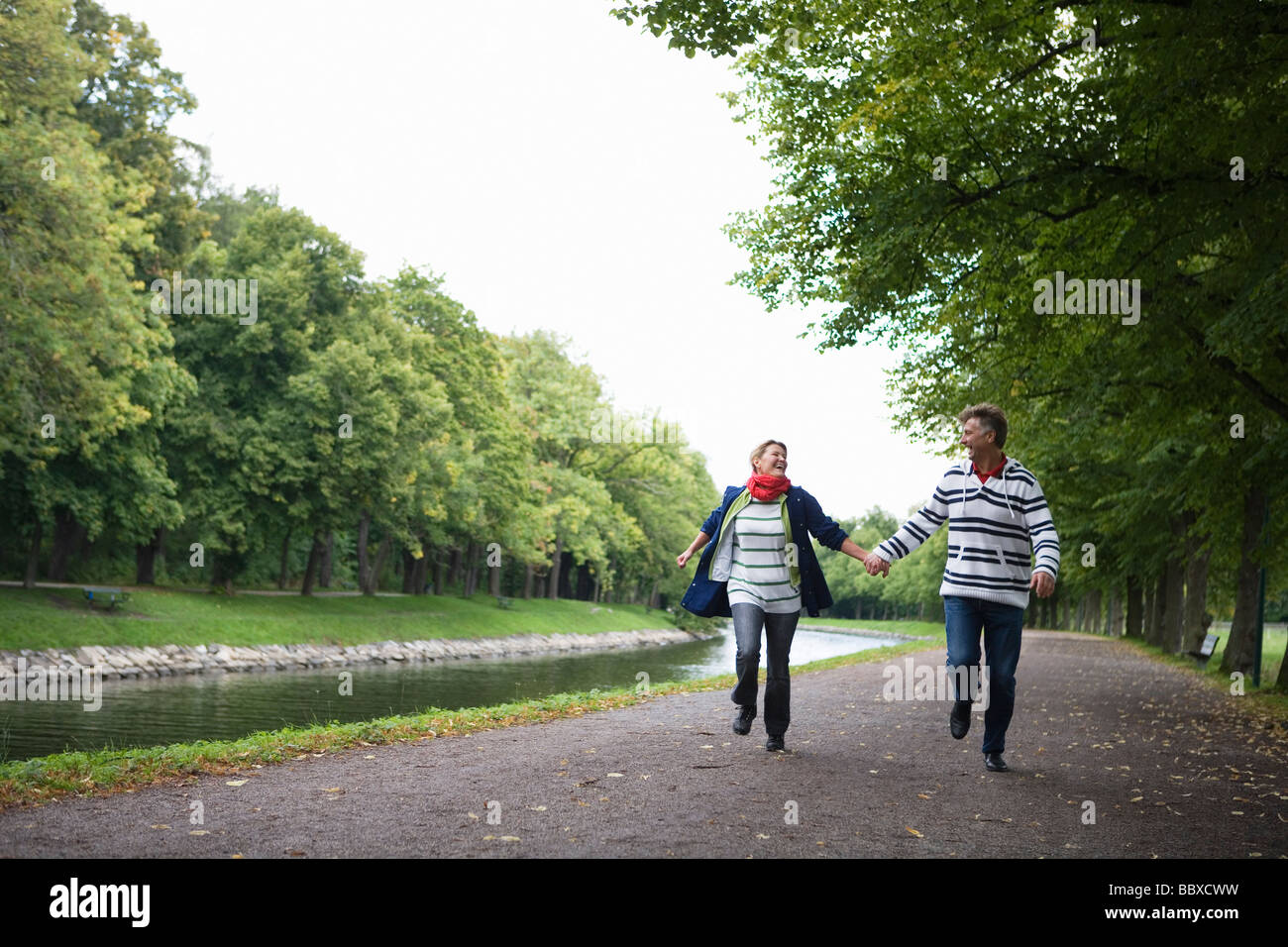 A couple running hand in hand in the park Sweden Stock Photo - Alamy