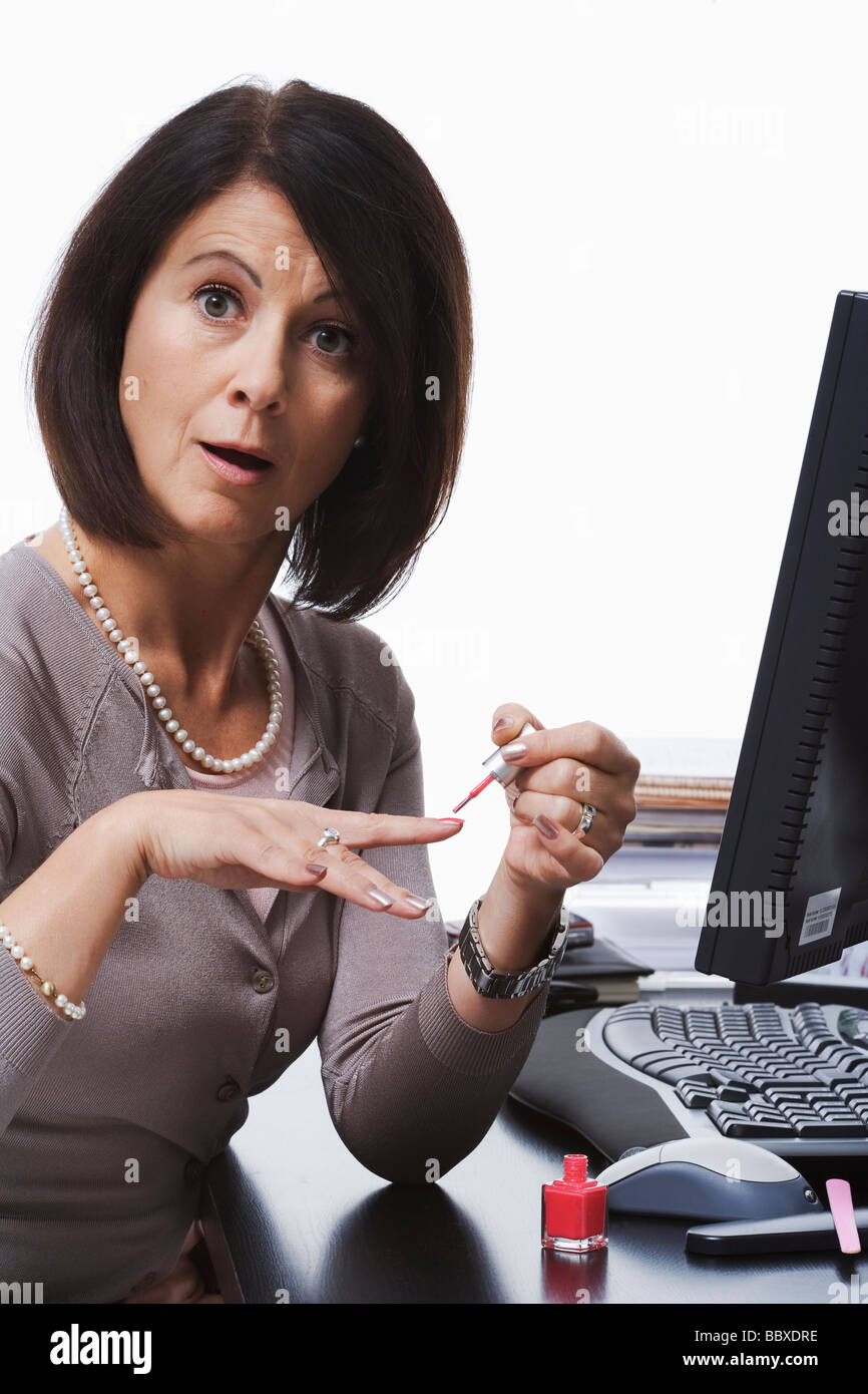 A woman doing her nails at the office Stock Photo - Alamy