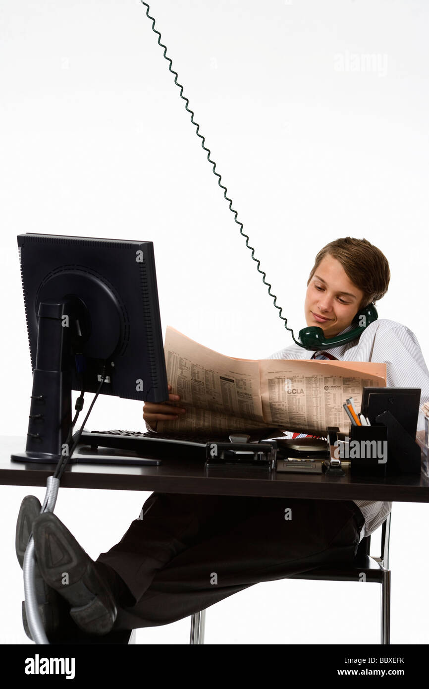 A teenage boy reading the paper Stock Photo - Alamy