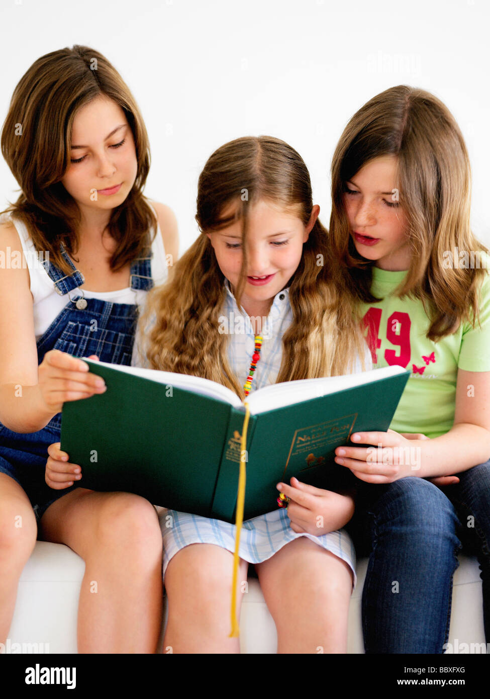 Three girls reading a book Sweden Stock Photo - Alamy