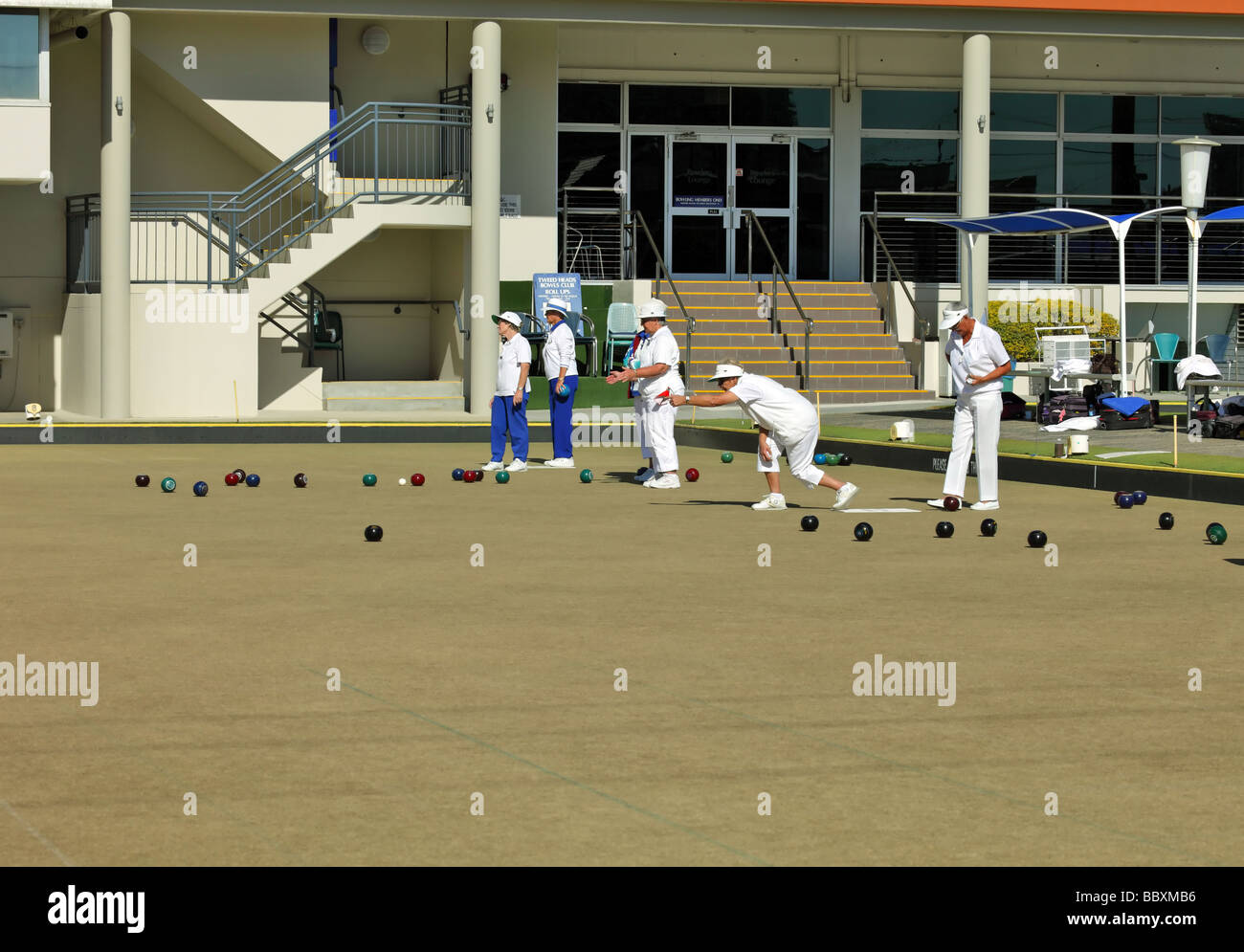 Woman at a lawn bowls tournament showing technique and bowling ...