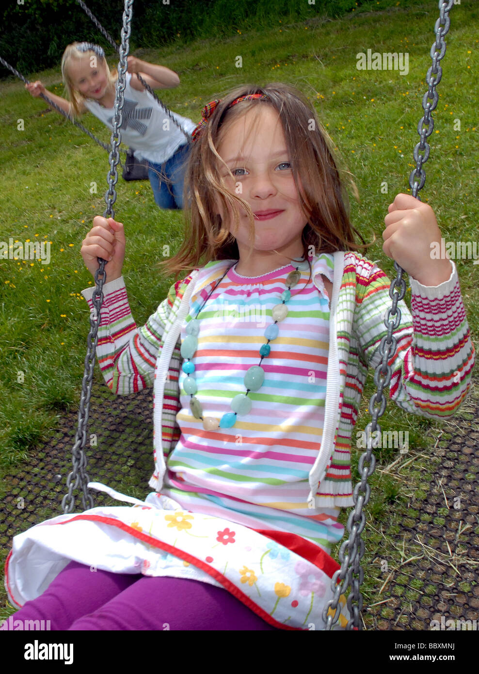 Young twin sisters playing on swings Stock Photo - Alamy
