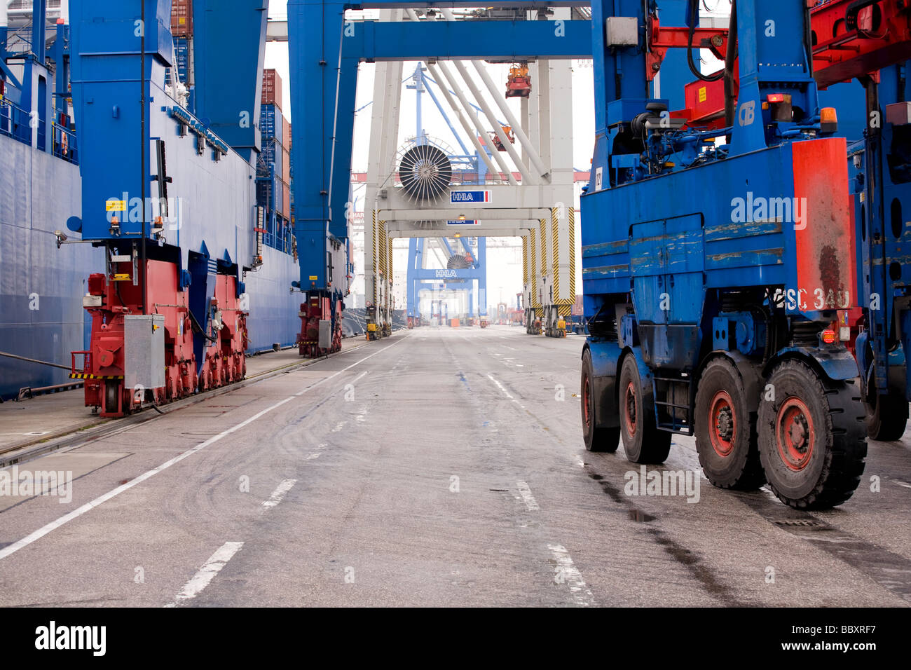 A straddle carrier truck prepares to move ISO containers from dockside ...