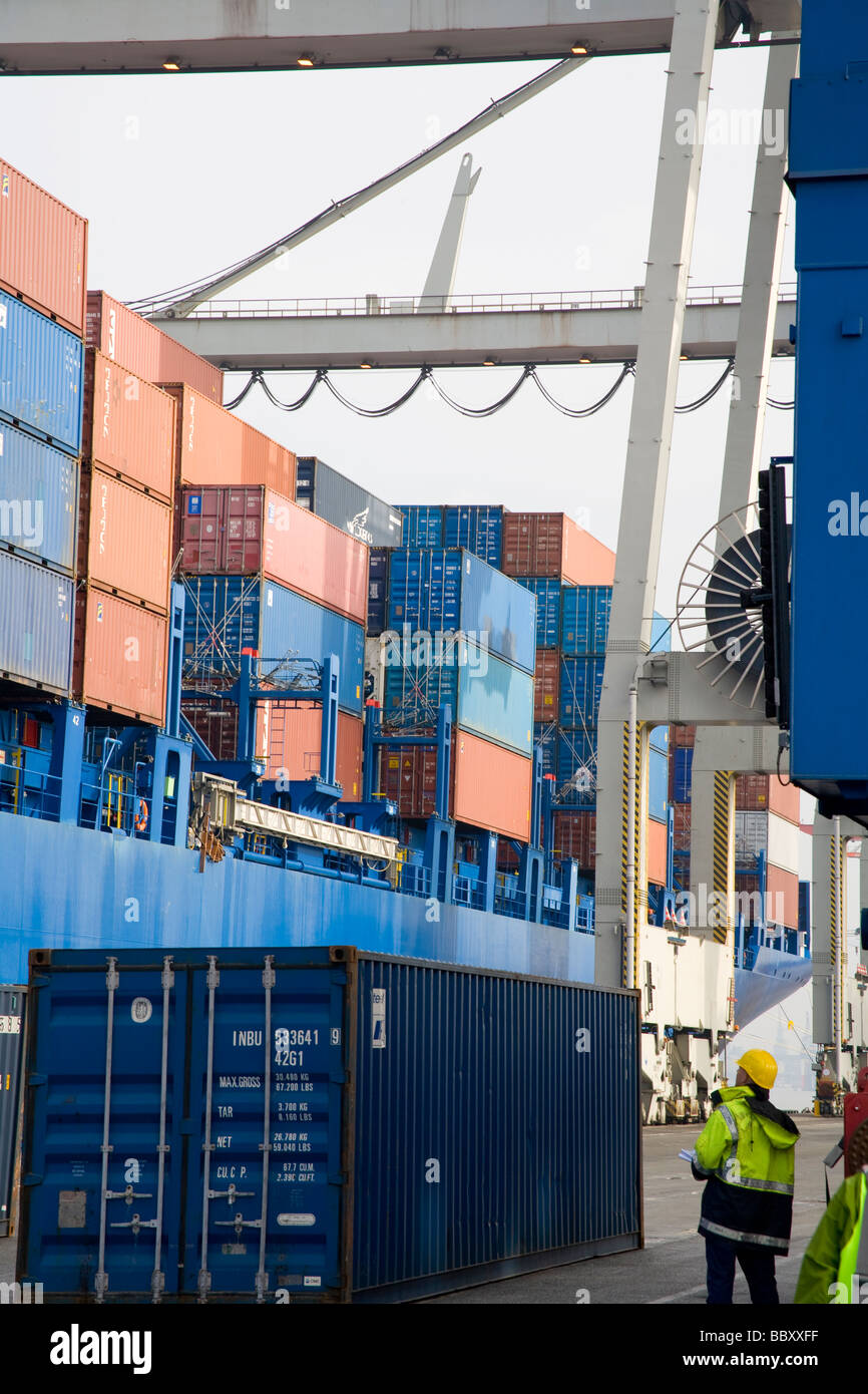 A docker overlooks containers onboard a docked containership waiting to ...