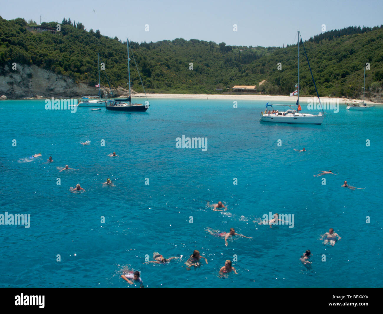 Yachts moored off the island of Anti Paxos Greece with many people ...
