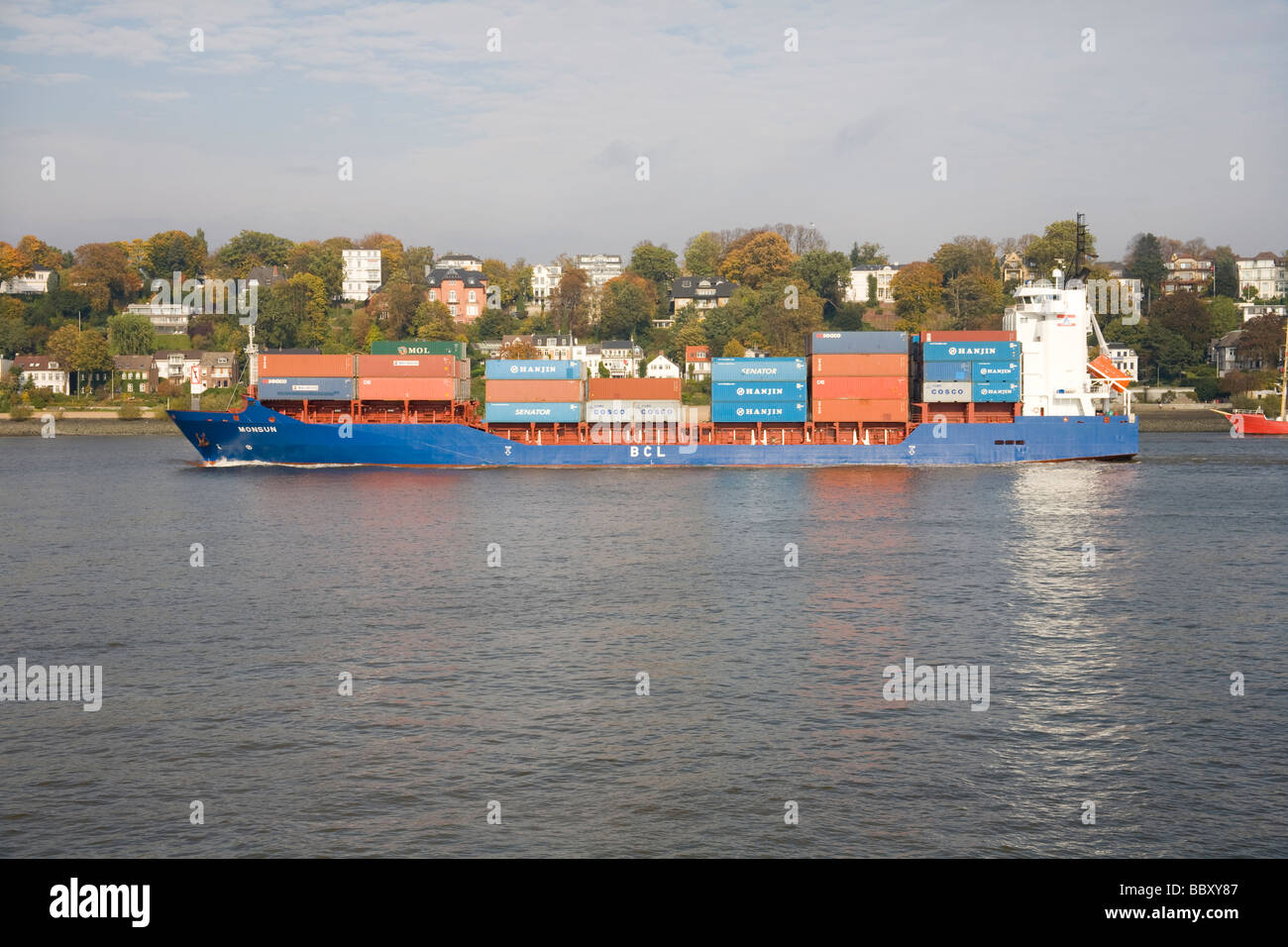 A small to medium size container ship heads out to see along the Elbe ...