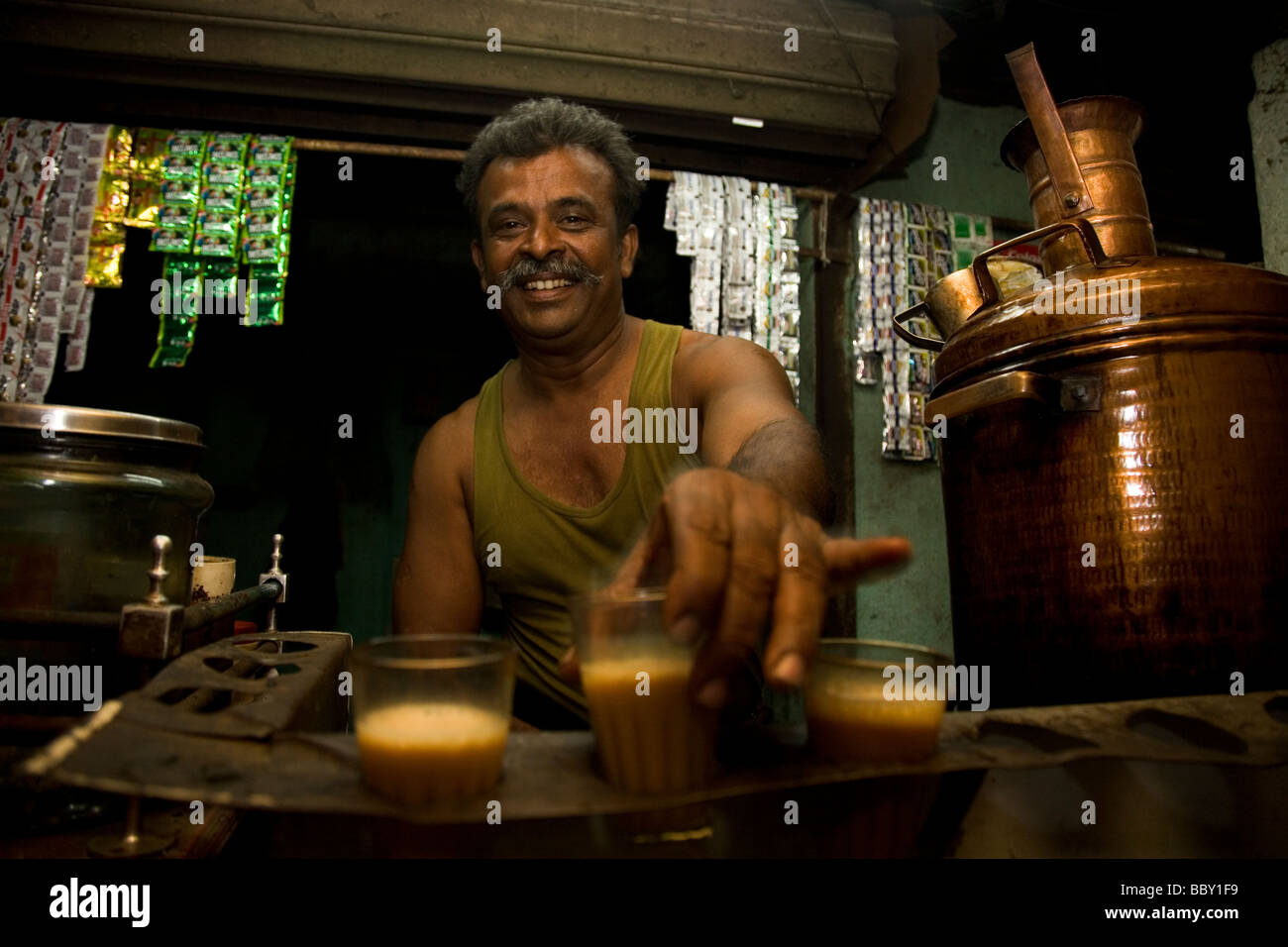 A man prepares tea in a teastall close to Chennai, India. He heats milk ...