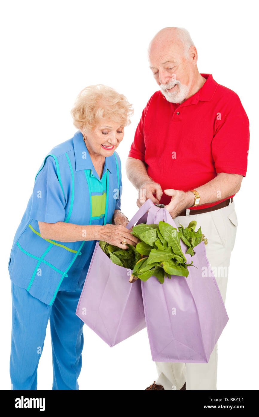 Seniors buying healthy produce and using recycleable grocery bags ...
