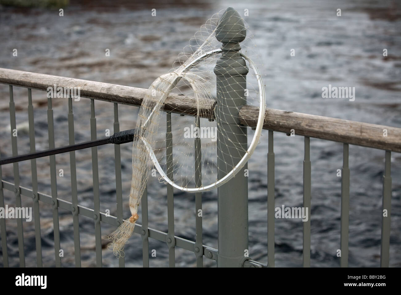 landing net hanging on grey iron fencing over the water Stock Photo - Alamy
