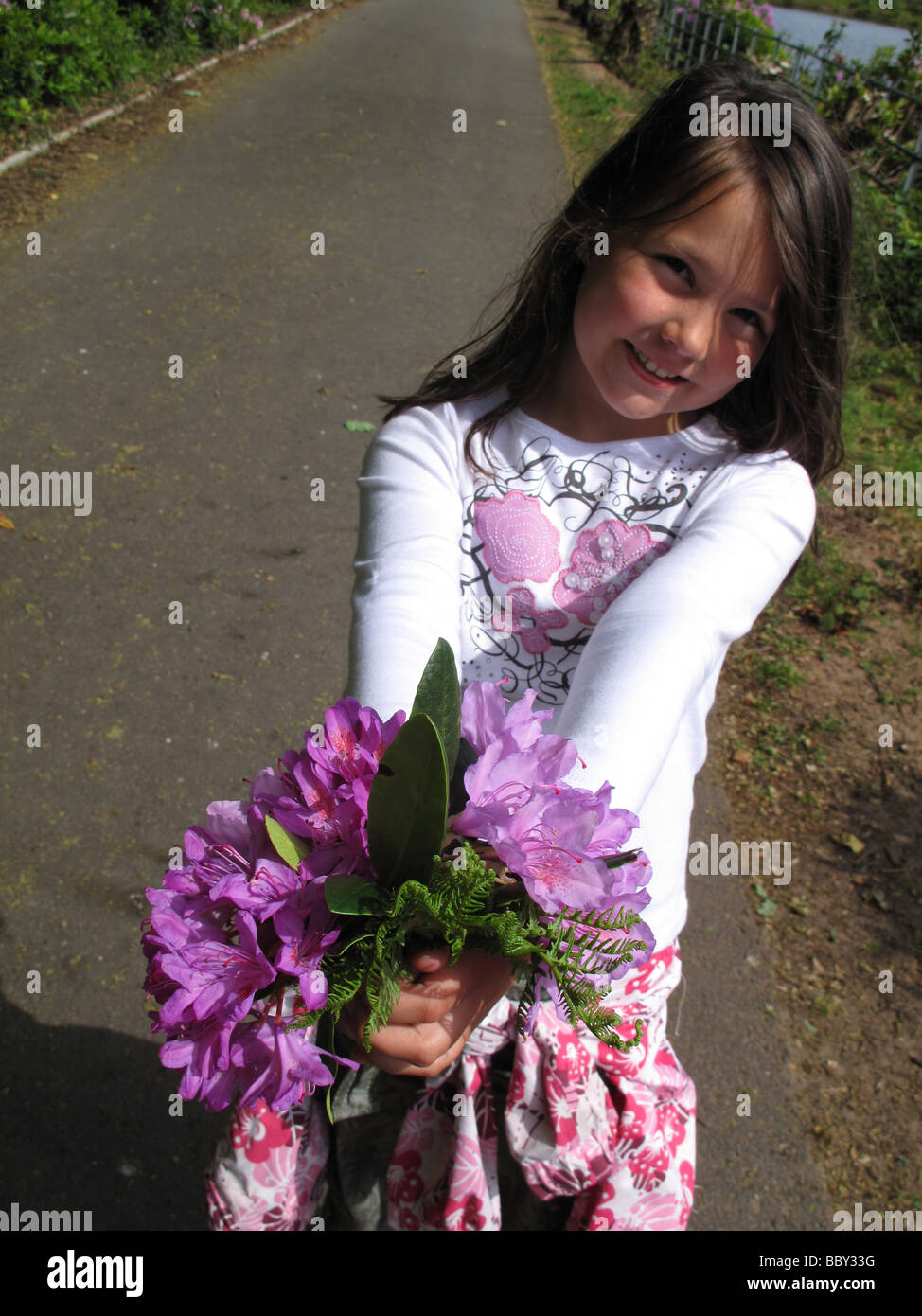 Young girl with bunch of picked flowers Stock Photo - Alamy