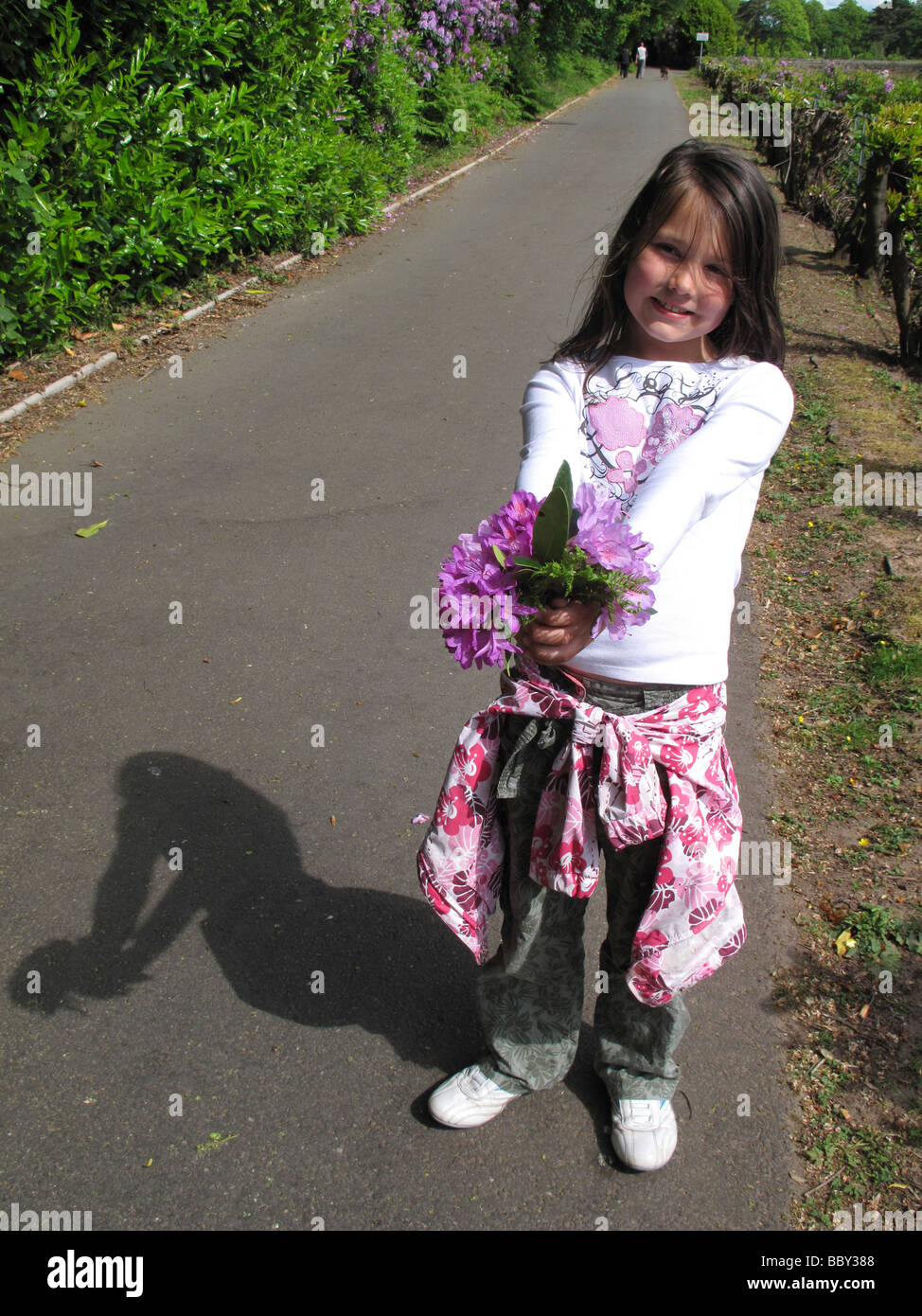 Young girl with bunch of picked flowers Stock Photo - Alamy