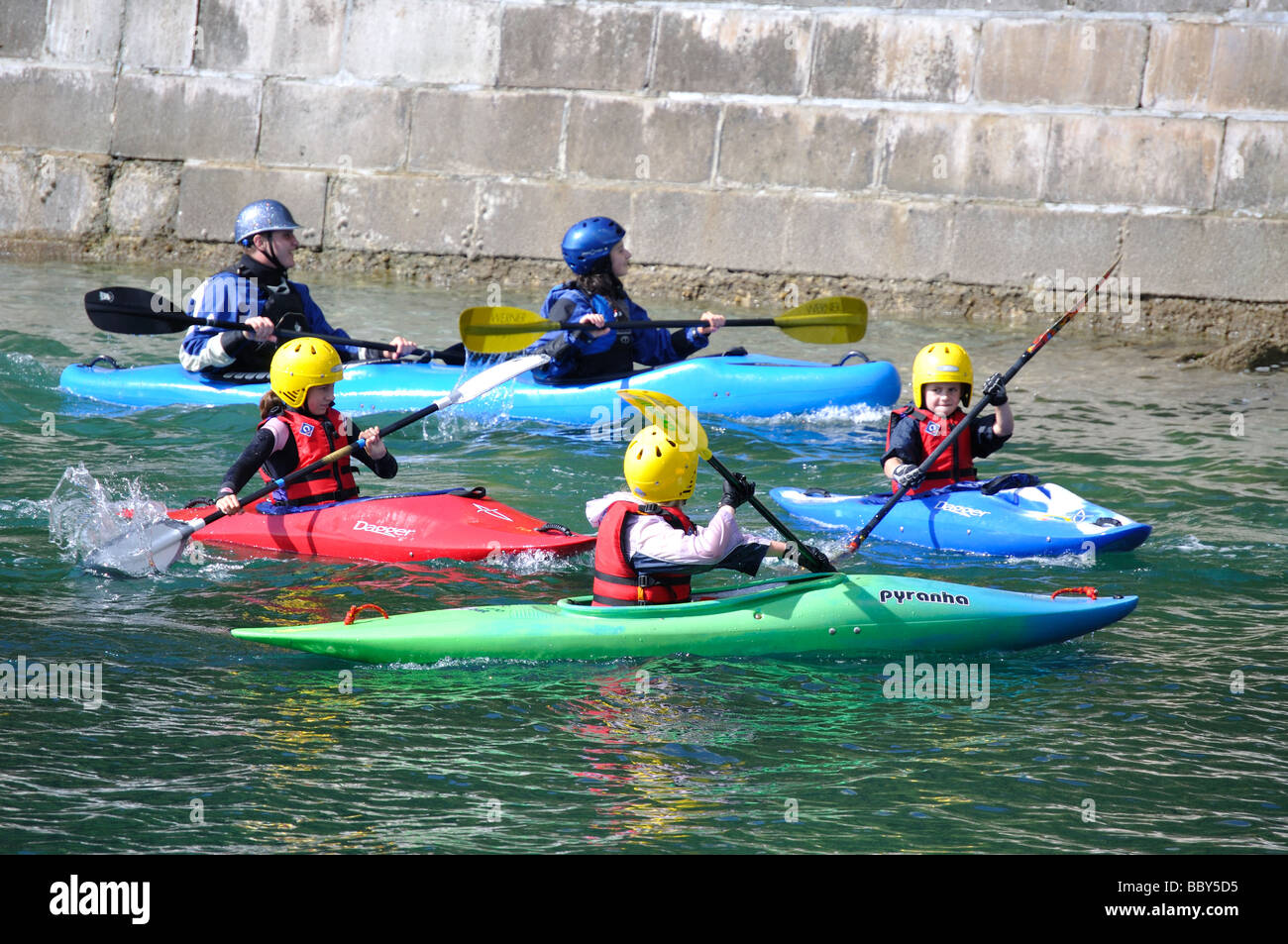 Children canoeing on harbour, Looe, Cornwall, England, United Kingdom ...