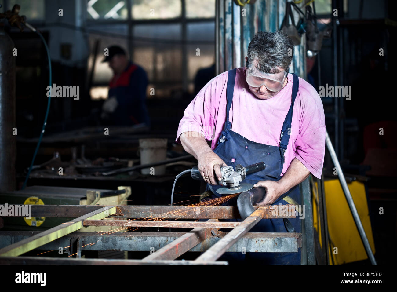 Workman using grinder in workshop Stock Photo - Alamy