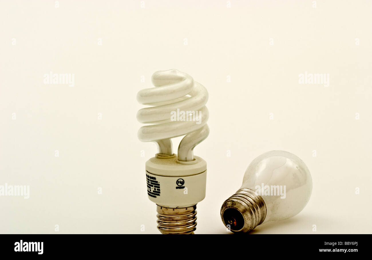 Two light bulbs, one energy saving standing, the other old fashioned ...