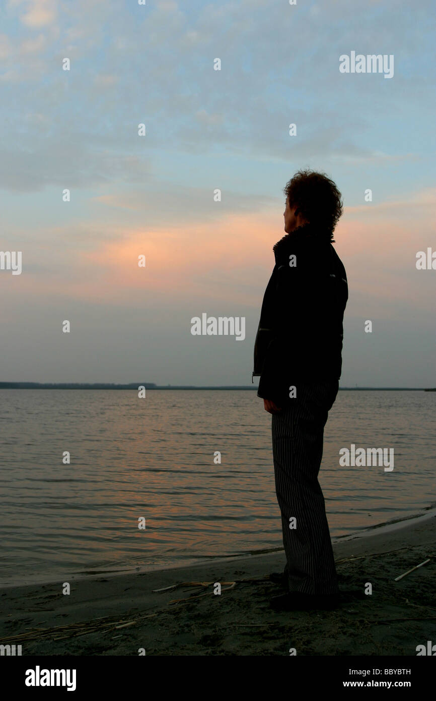 Contemplative woman thinking at beach silhouette Stock Photo - Alamy