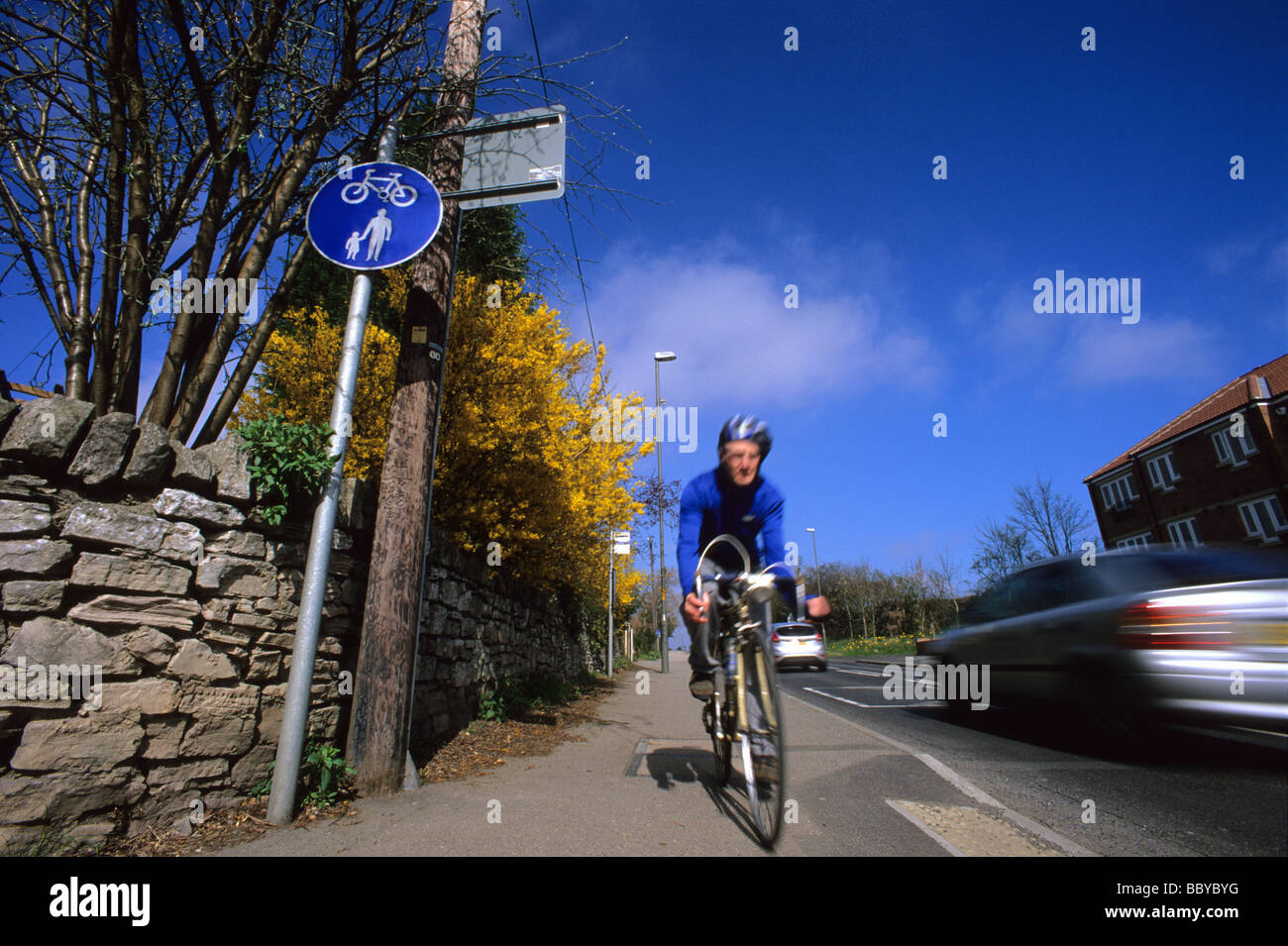 cyclist riding on cycle lane in the village near leeds yorkshire uk ...