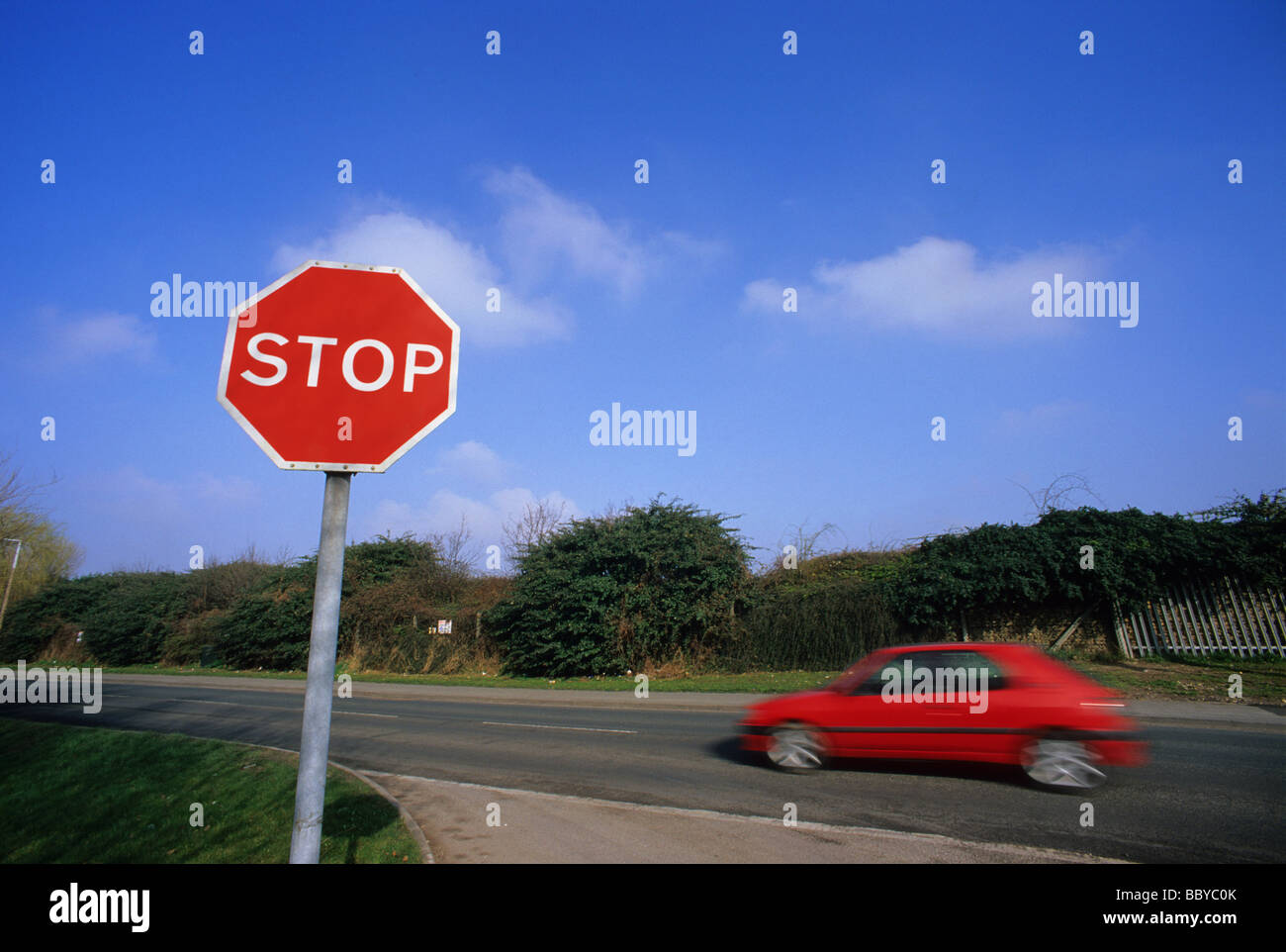 car and lorry passing stop sign at road junction near Leeds Yorkshire ...