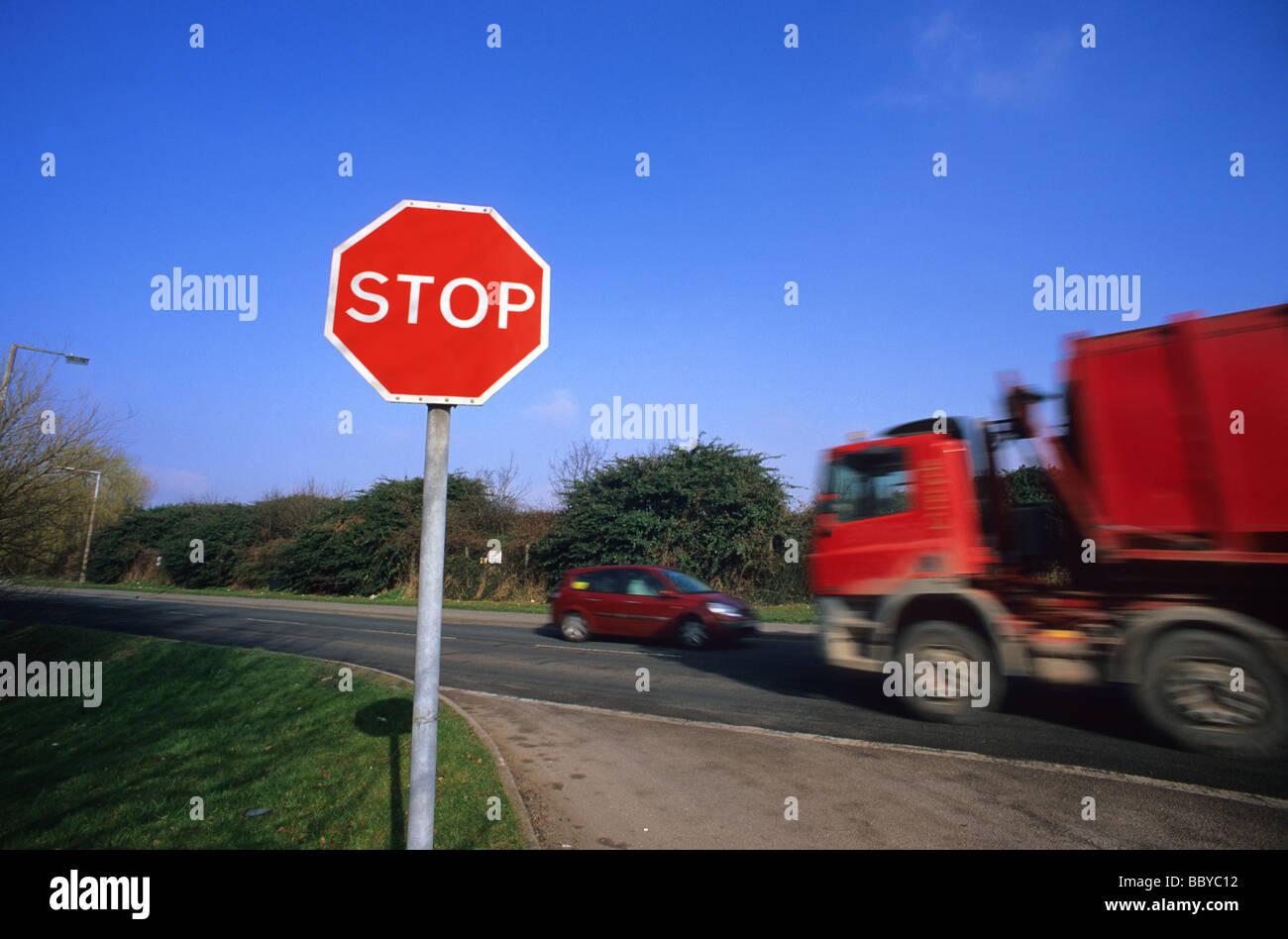 car and lorry passing stop sign at road junction near Leeds Yorkshire ...