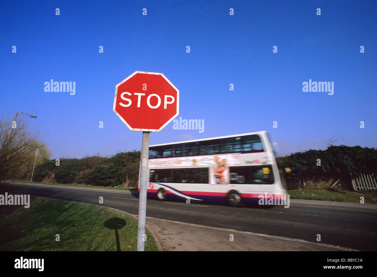 bus passing stop sign at road junction near Leeds Yorkshire UK Stock ...