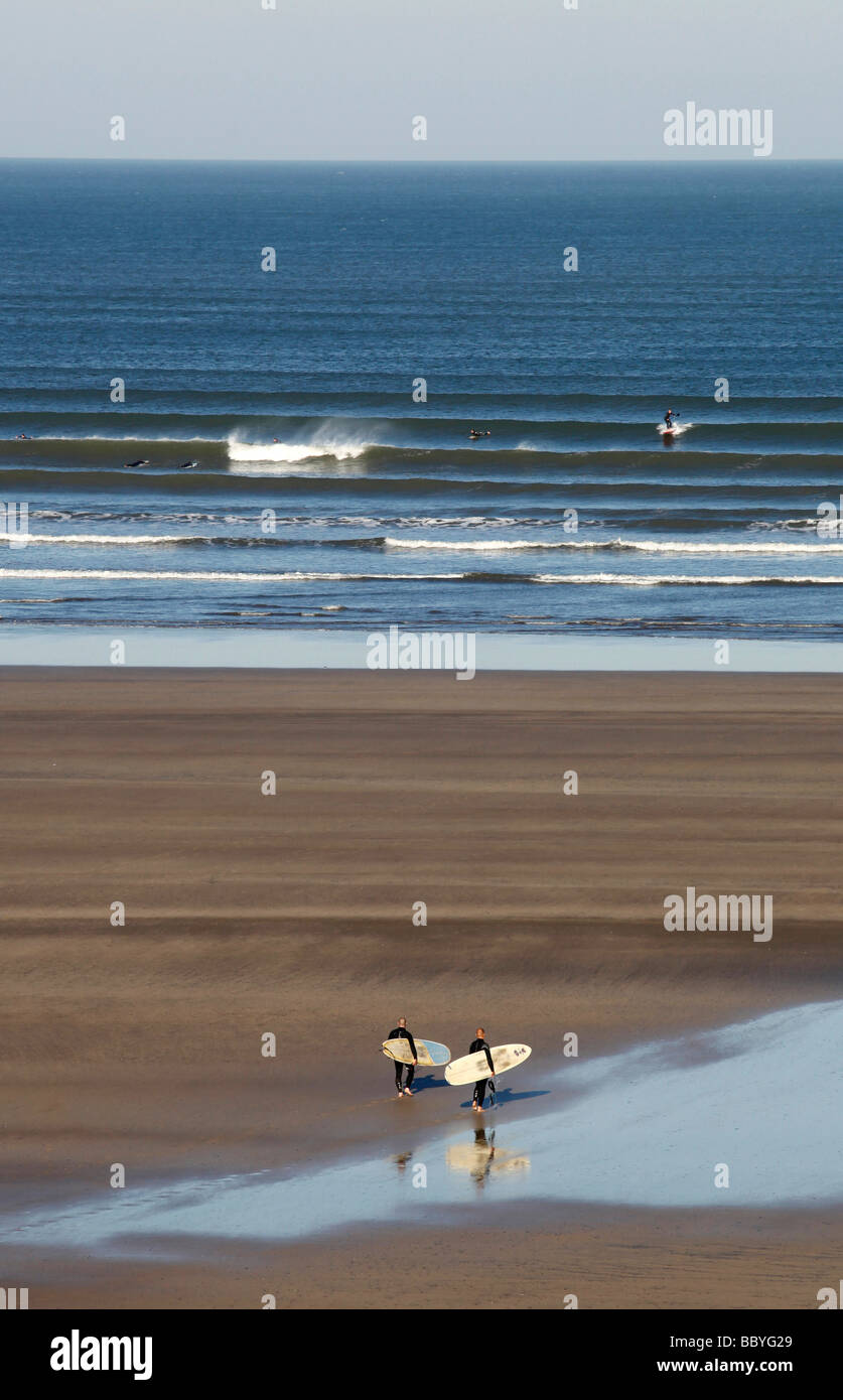Surfers walking across the beach towards the sea Stock Photo - Alamy