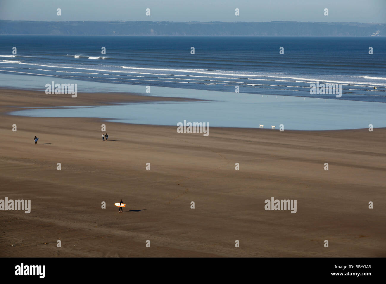 Surfers walking across the beach towards the sea Stock Photo - Alamy