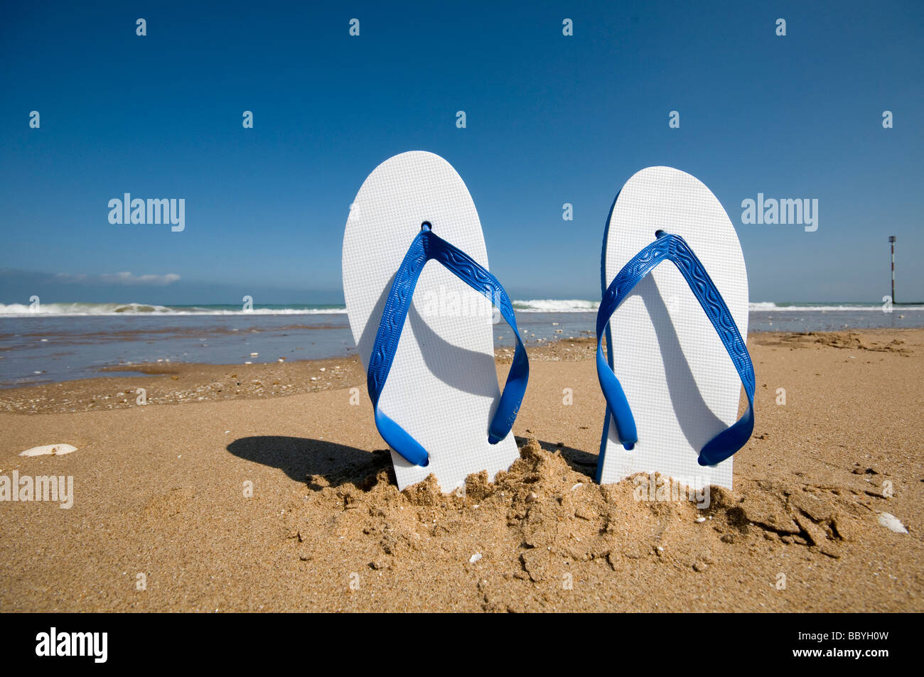 Flip flops and in sand on beach Stock Photo - Alamy