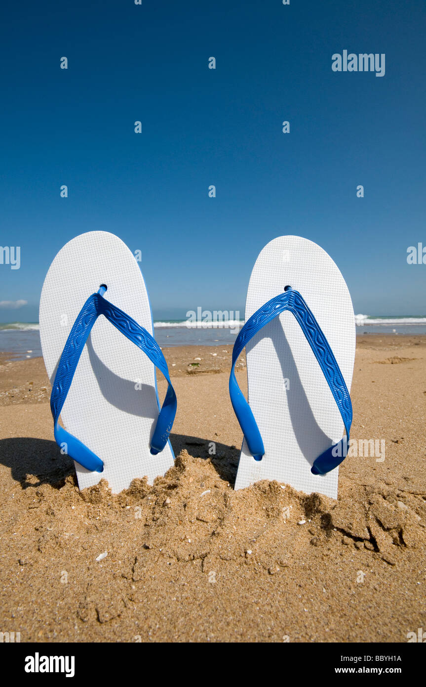 Flip flops and in sand on beach Stock Photo - Alamy