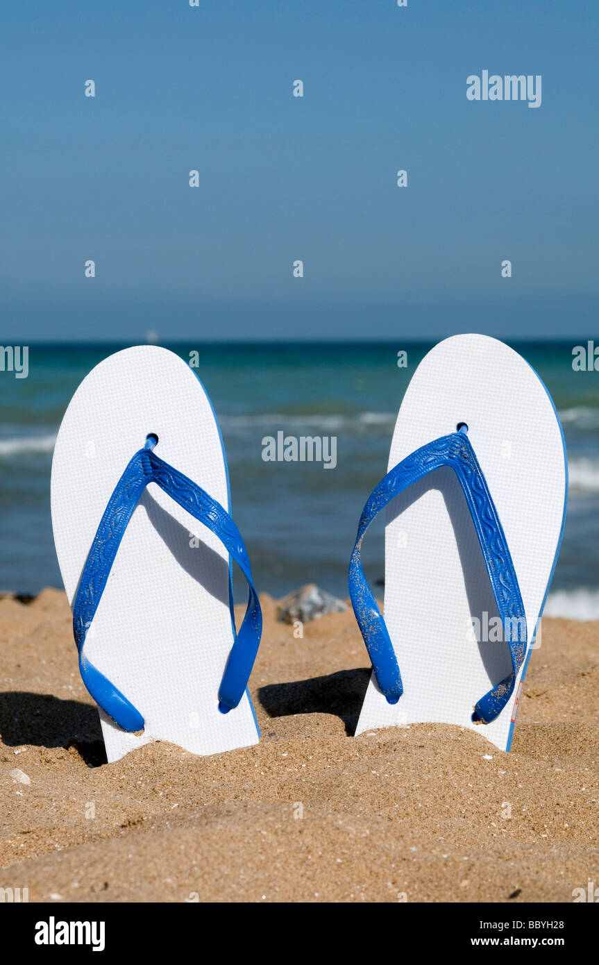 Flip flops and in sand on beach Stock Photo - Alamy