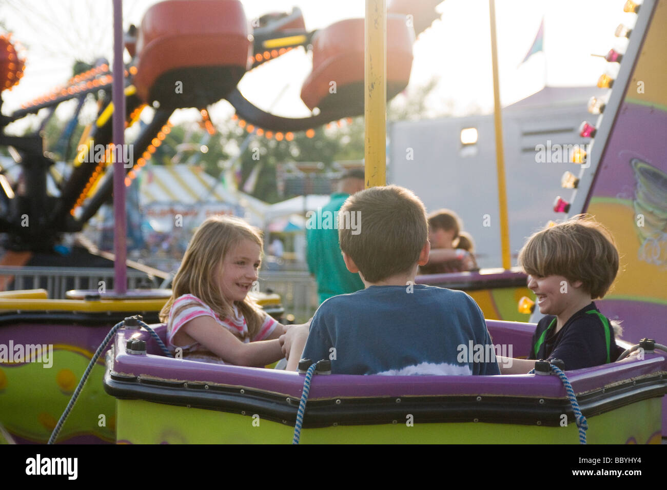 Kids sitting in amusement park ride Stock Photo - Alamy