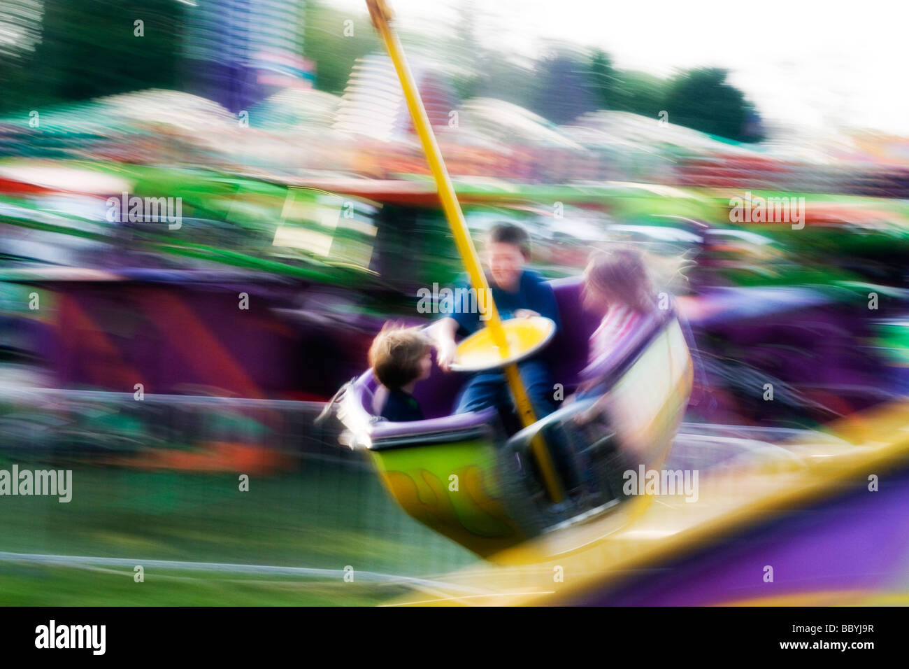 Kids twirling around on amusement ride Stock Photo - Alamy