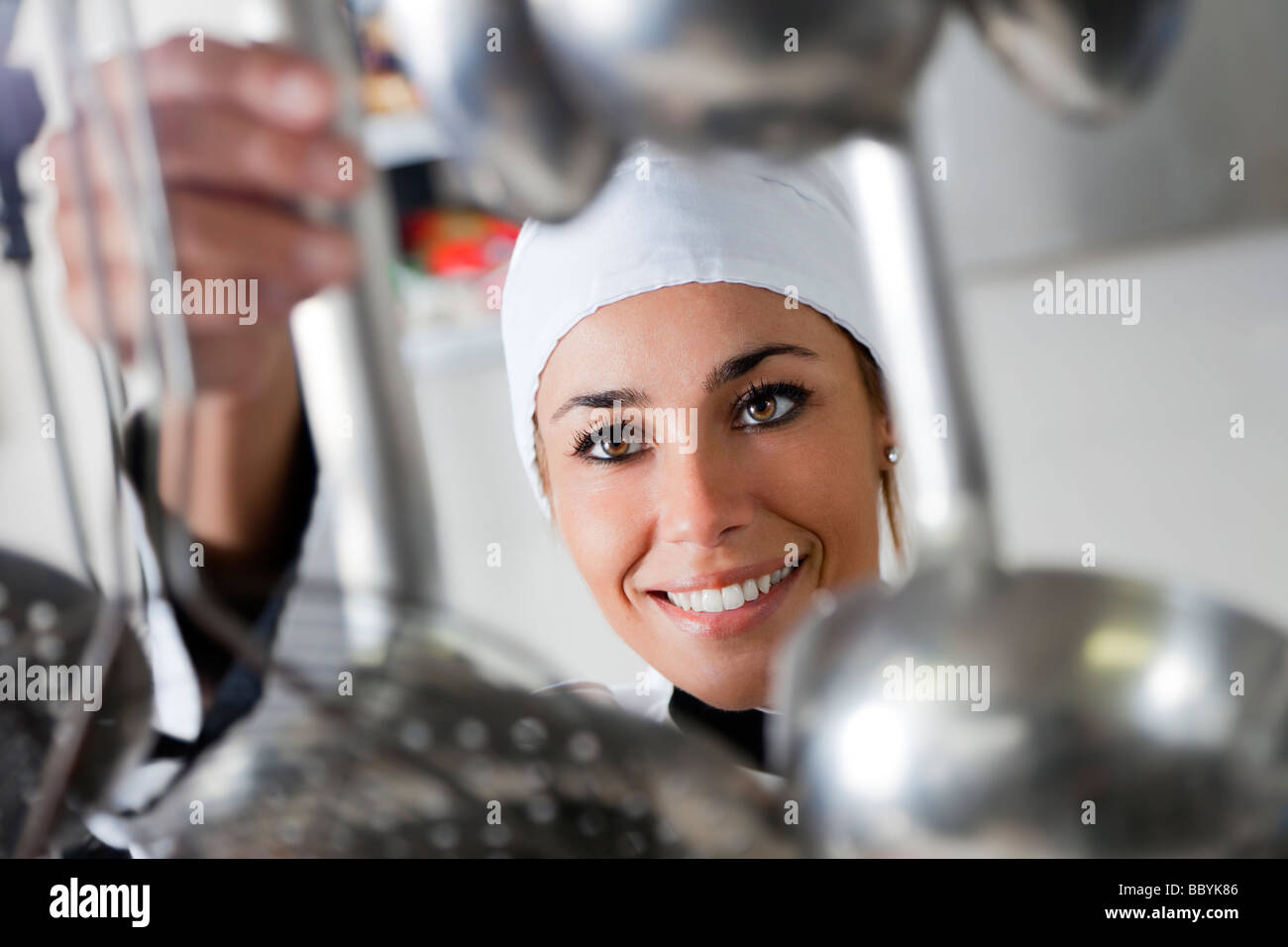 mid adult female chef taking kitchen utensil Stock Photo - Alamy
